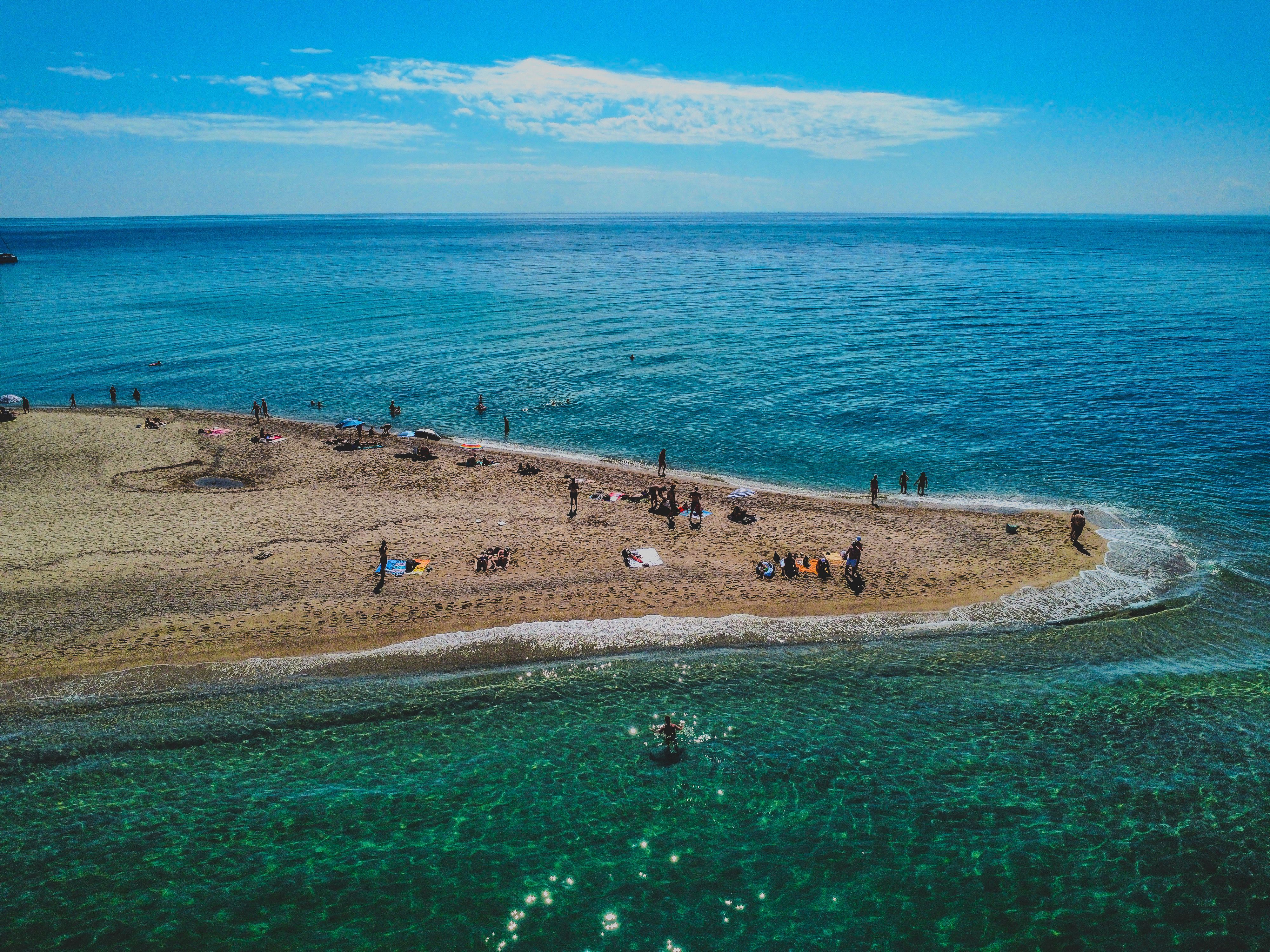 Aerial View of Relaxing Beachgoers on Sandy Shore · Free Stock Photo