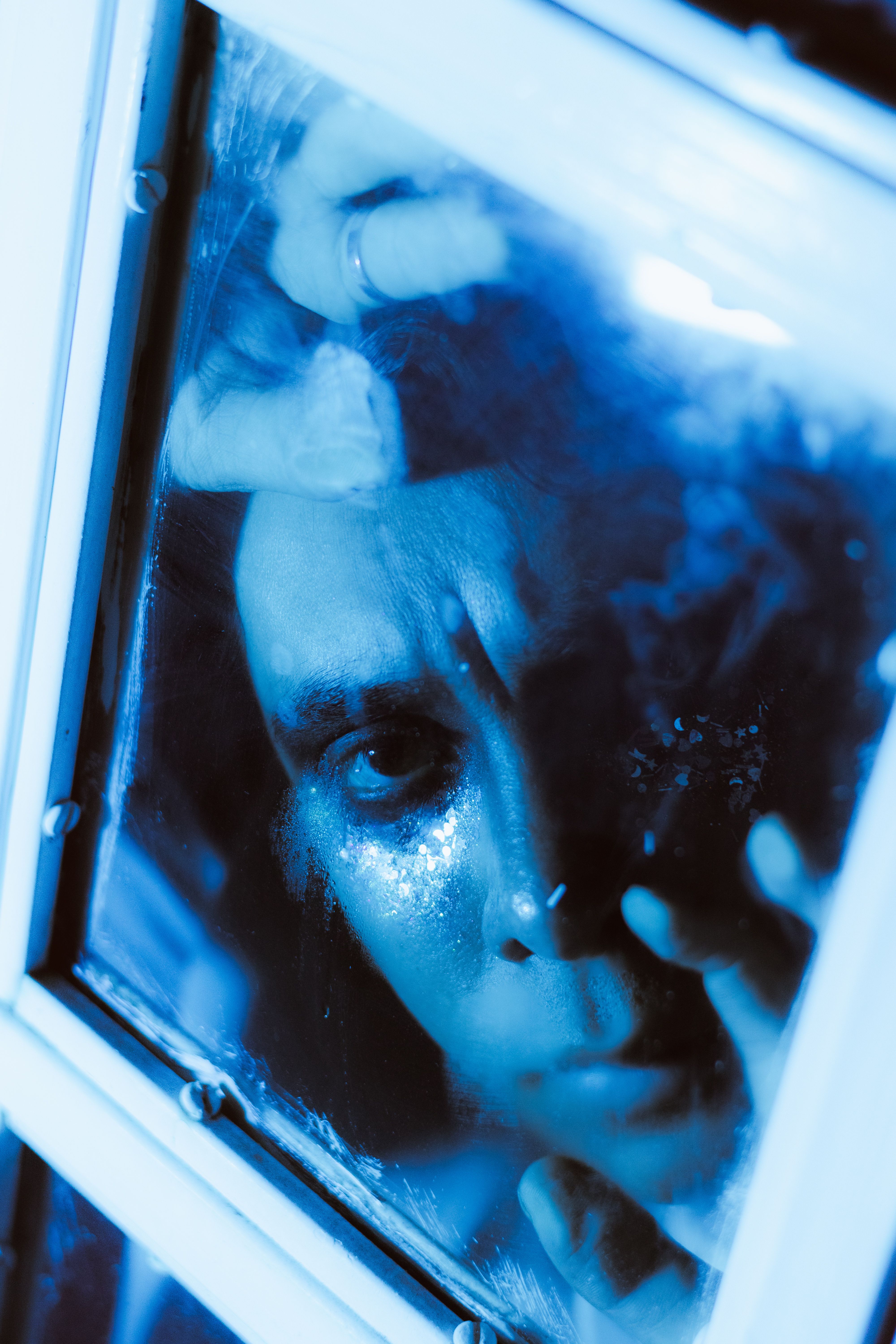 Moody Portrait through Frosted Window · Free Stock Photo