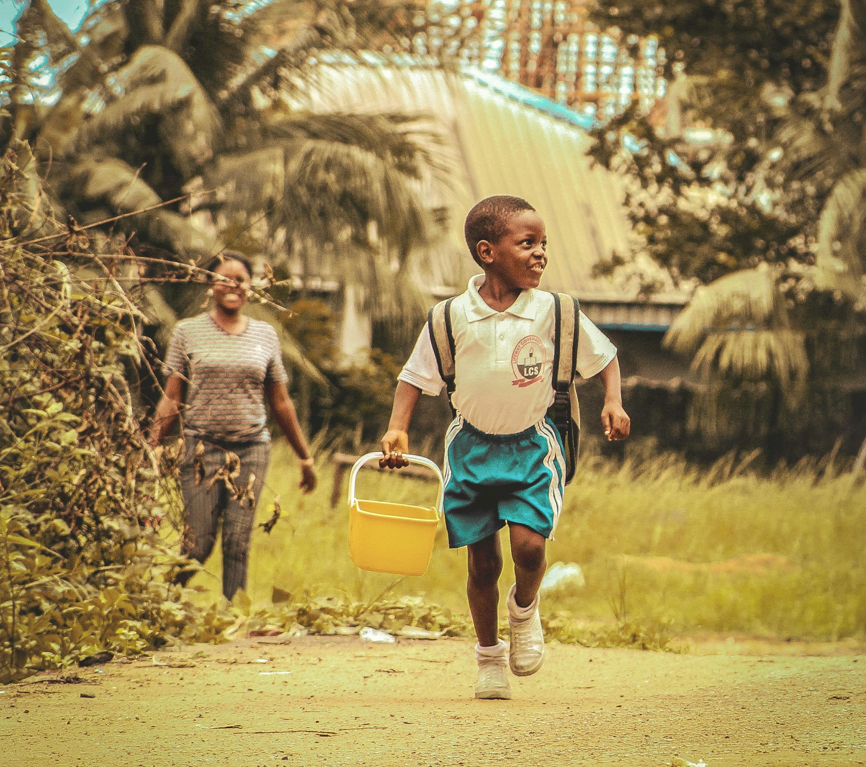 Joyful African Child Running Outdoors with Backpack · Free Stock Photo