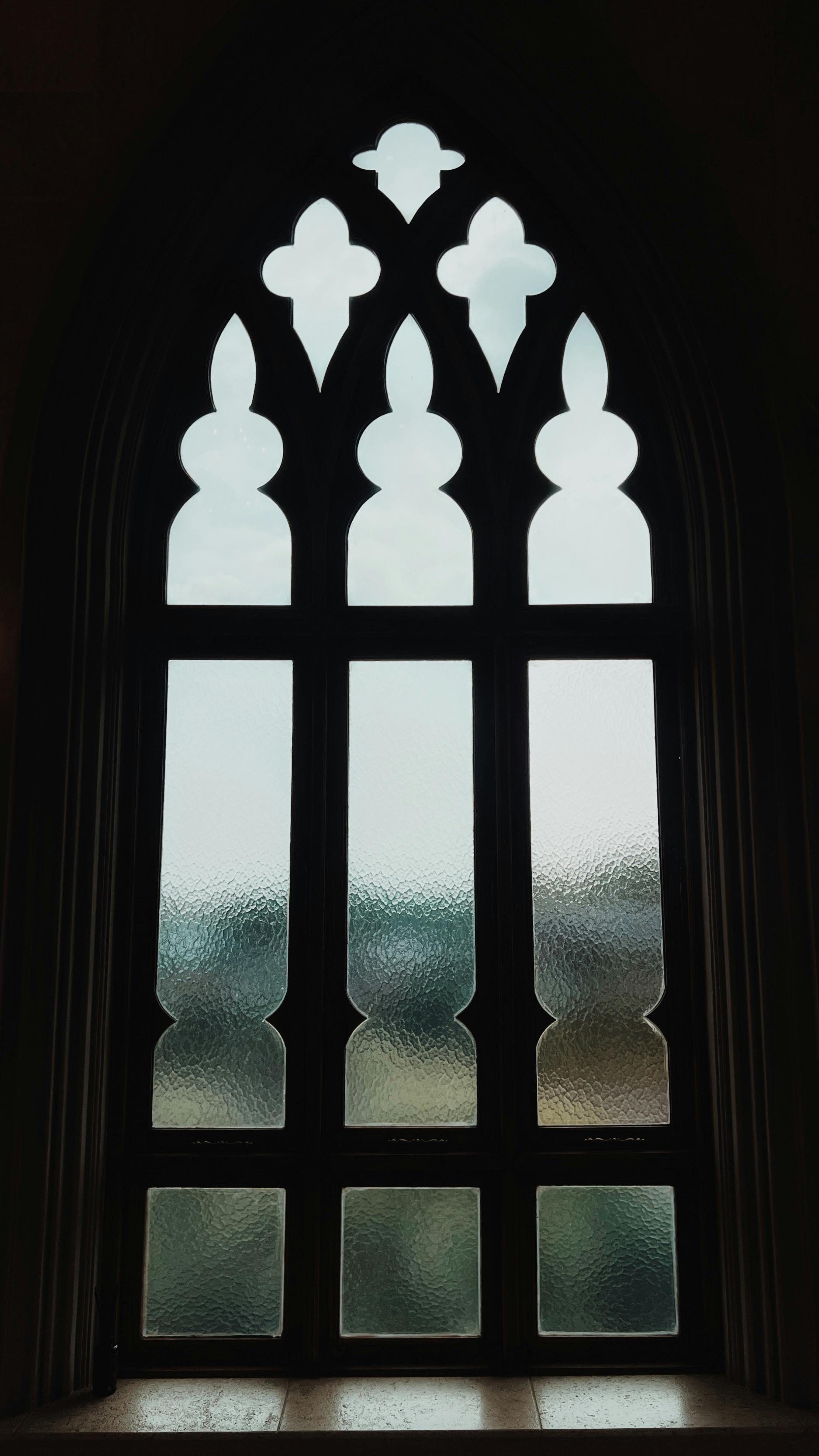 Gothic Arched Stained Glass Window in Shadow · Free Stock Photo