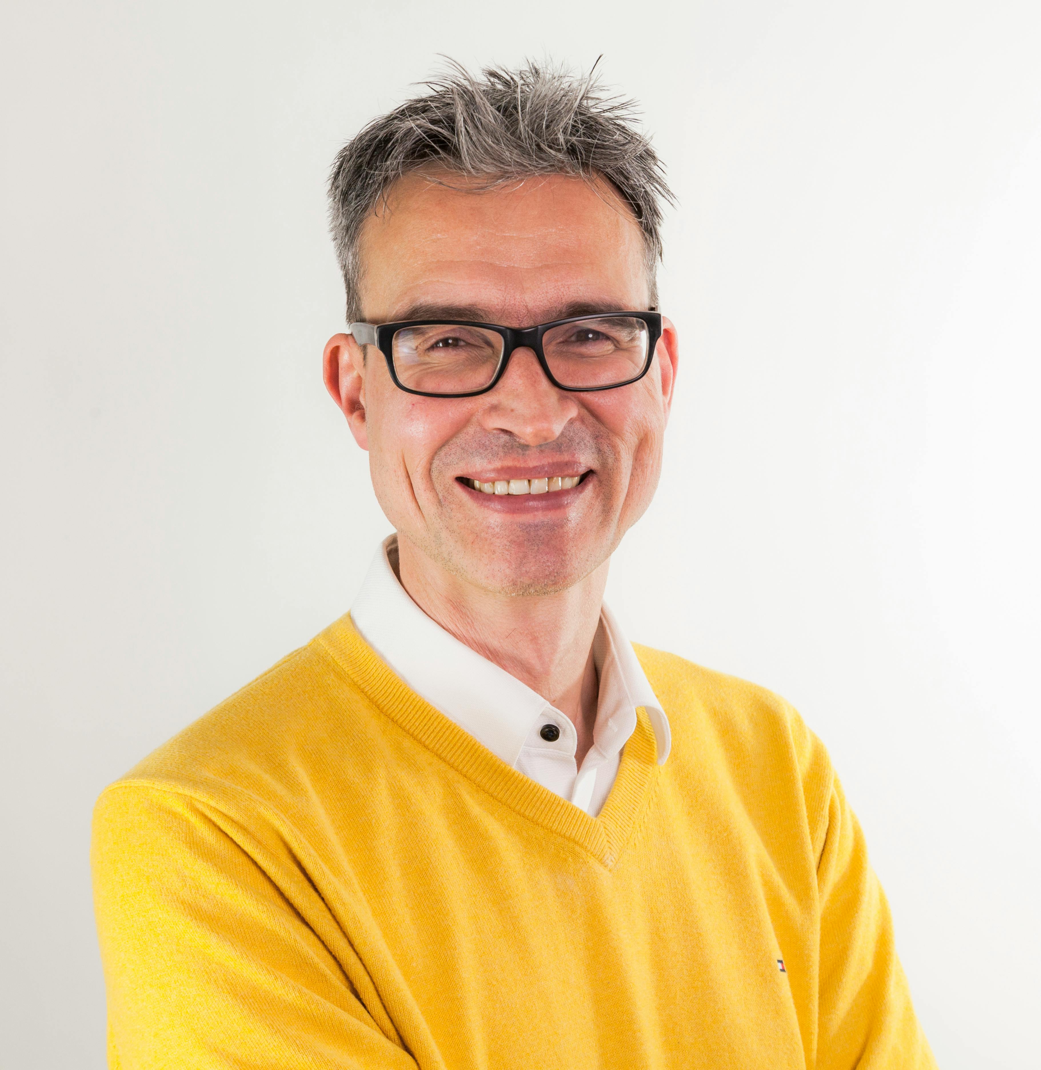 Smiling Man in Yellow Sweater with Glasses · Free Stock Photo