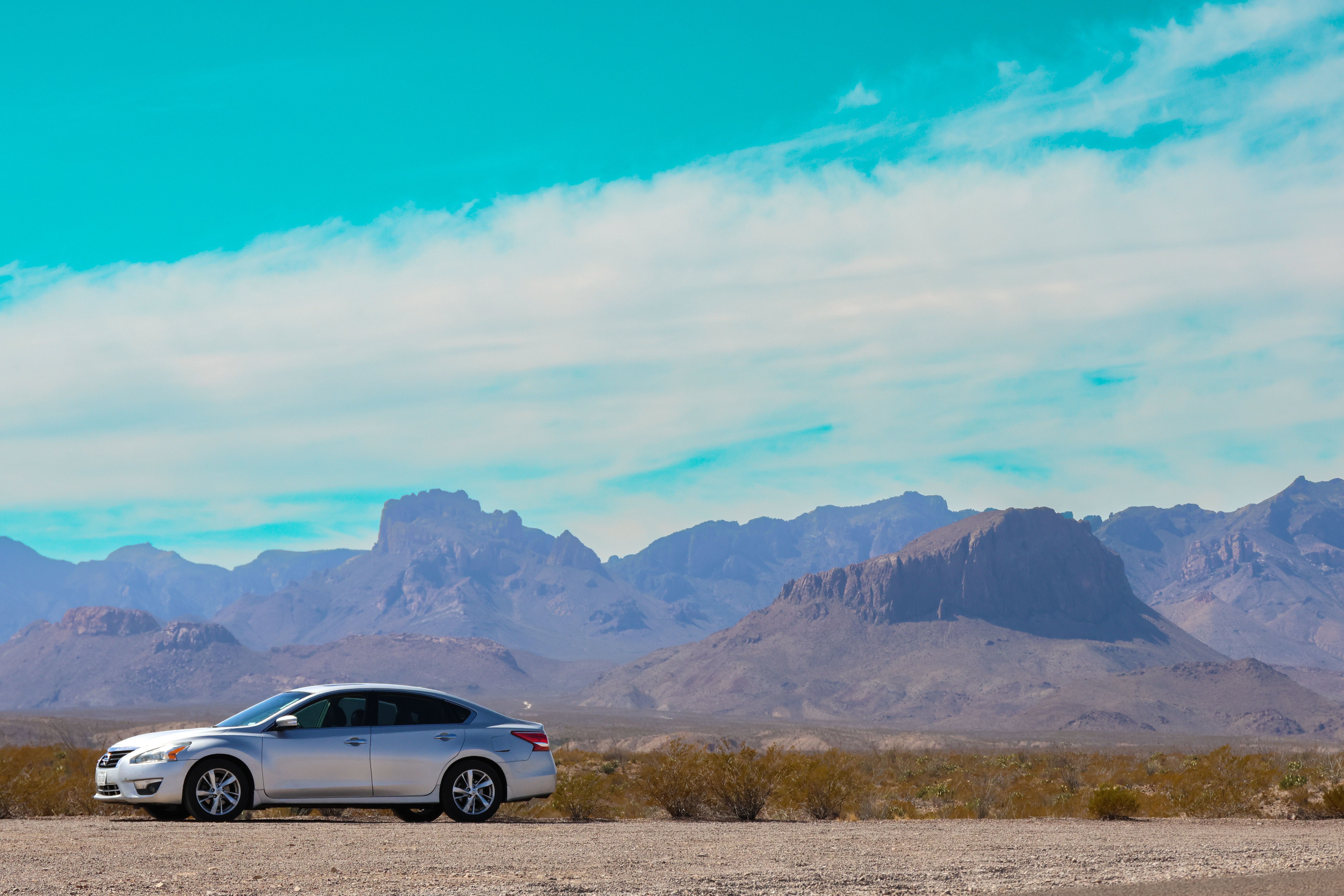 Scenic Desert Drive with Car and Mountain View · Free Stock Photo