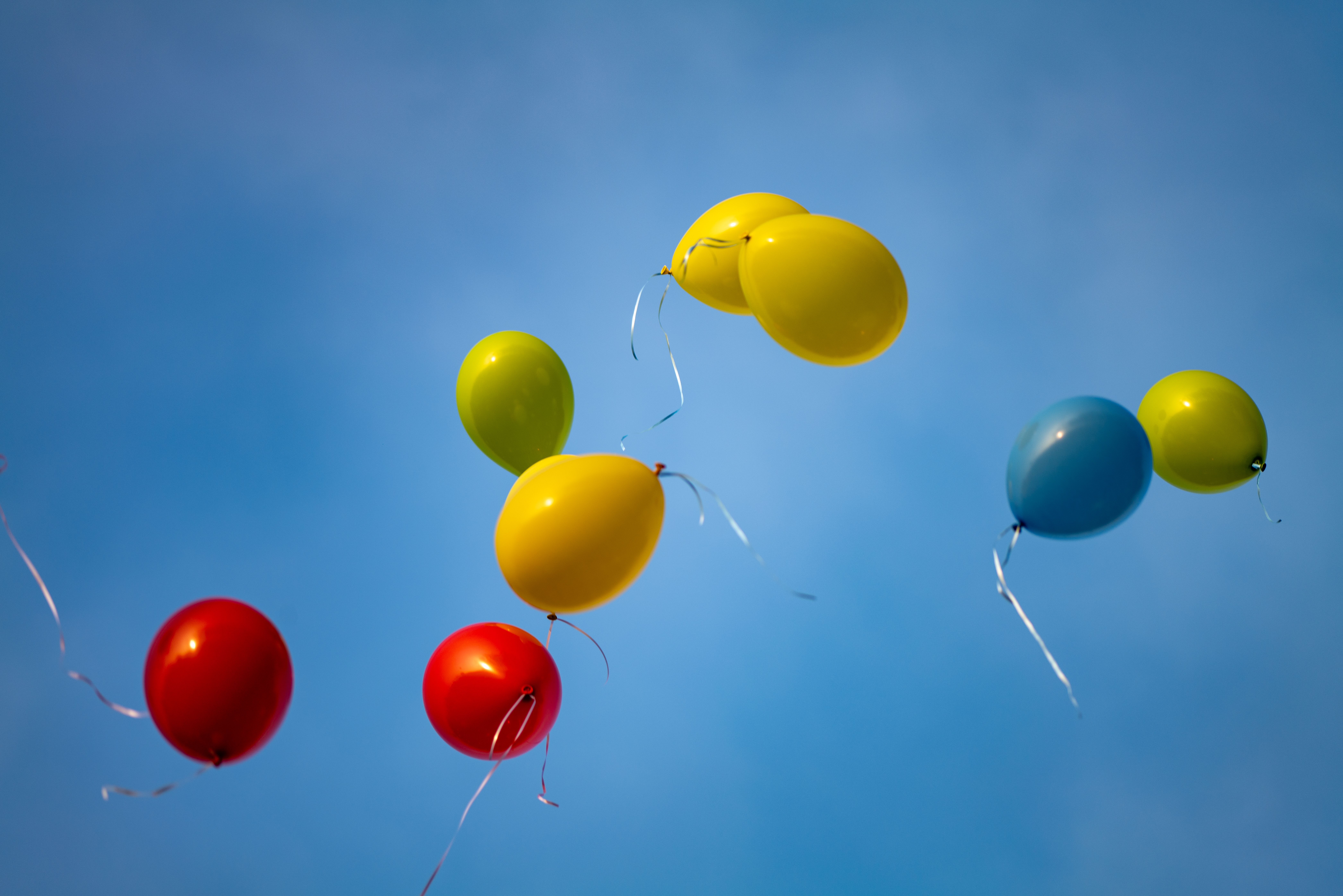 Colorful Balloons Floating Against Blue Sky · Free Stock Photo