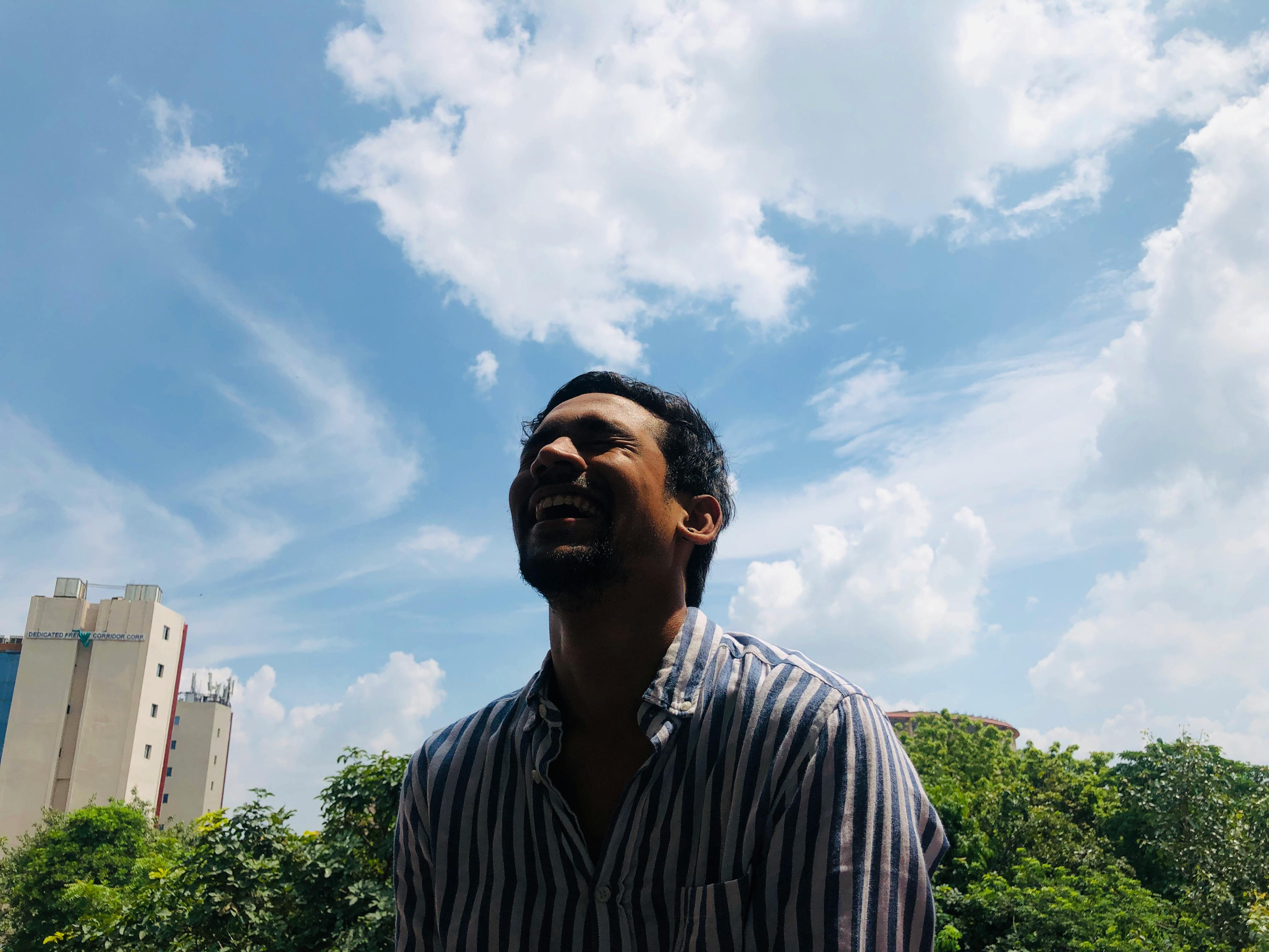 Happy ethnic man laughing in park · Free Stock Photo