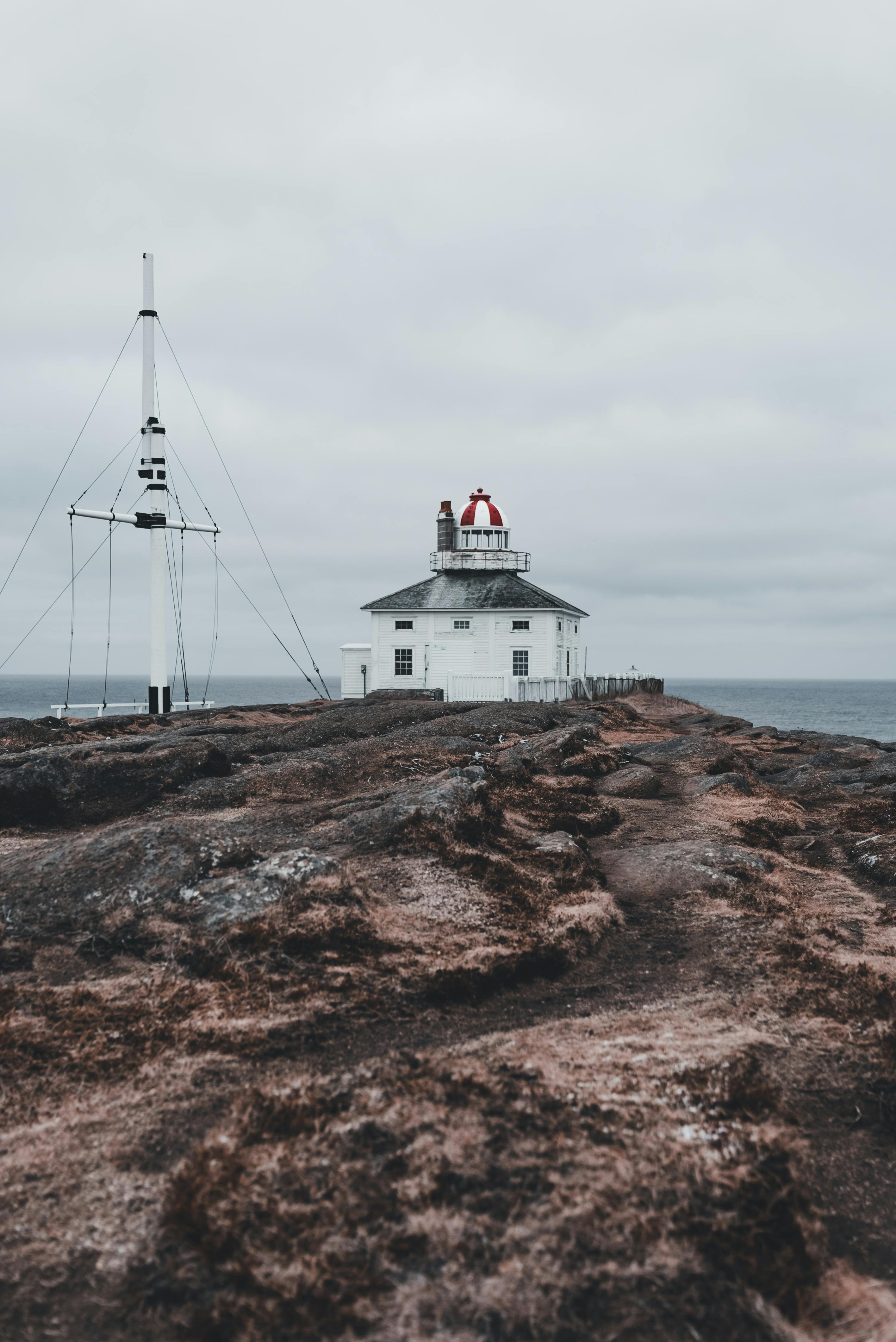 Remote Coastal Lighthouse on Rocky Seashore · Free Stock Photo