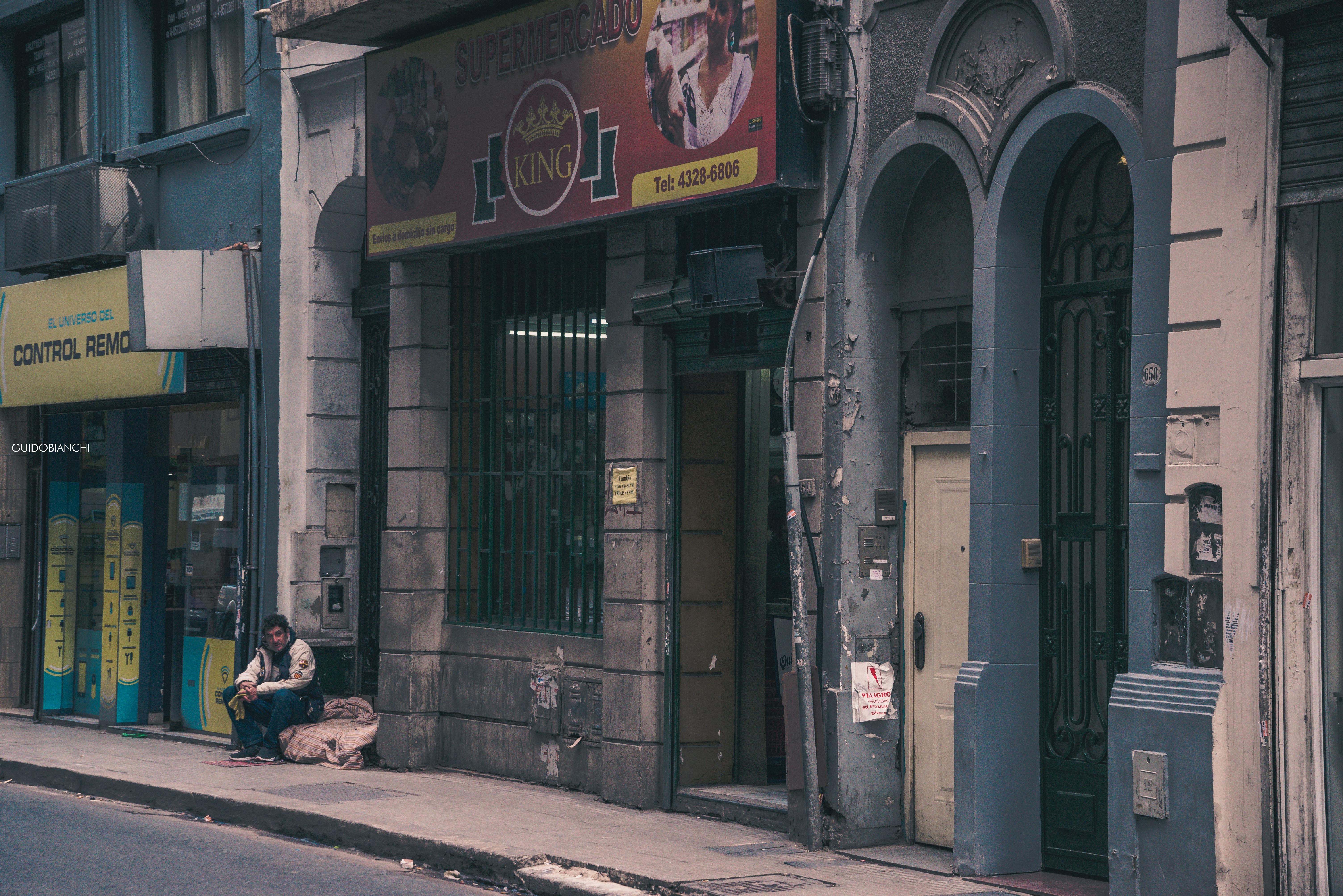 Urban Street Scene with Person Sitting Outside · Free Stock Photo