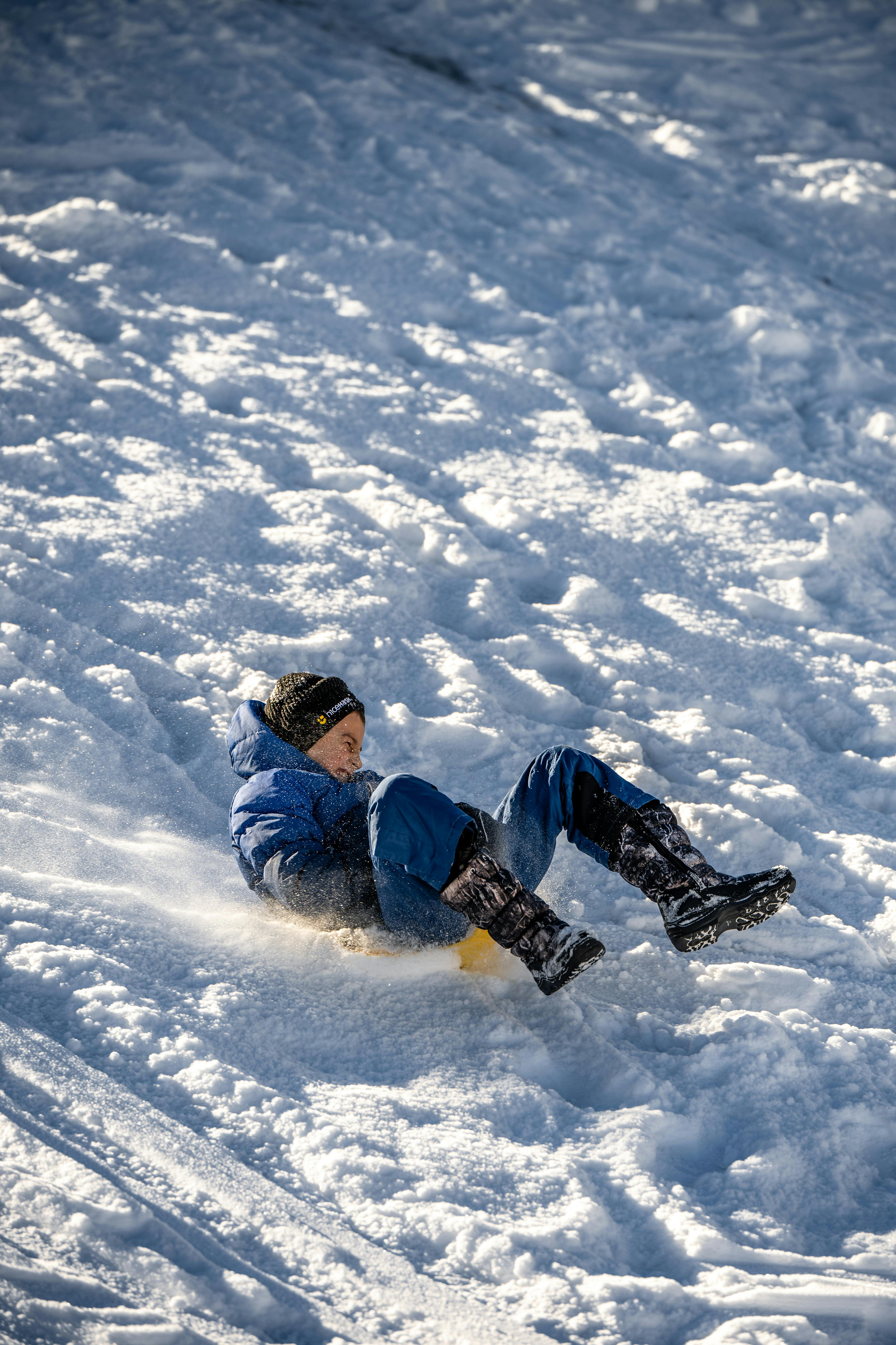 Boy Sledding Down Snowy Slope in Planica · Free Stock Photo