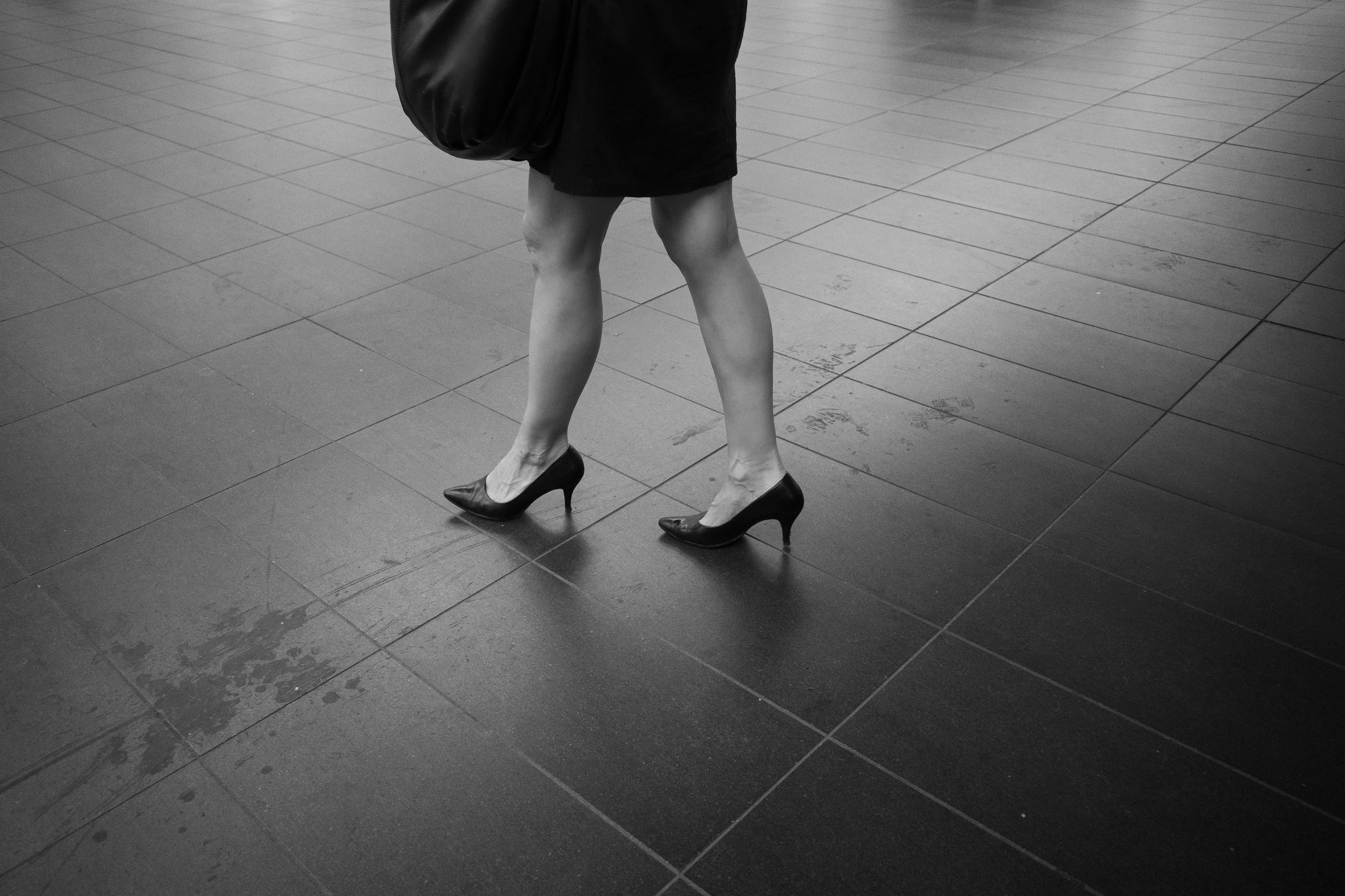 Woman Walking in High Heels on City Sidewalk · Free Stock Photo