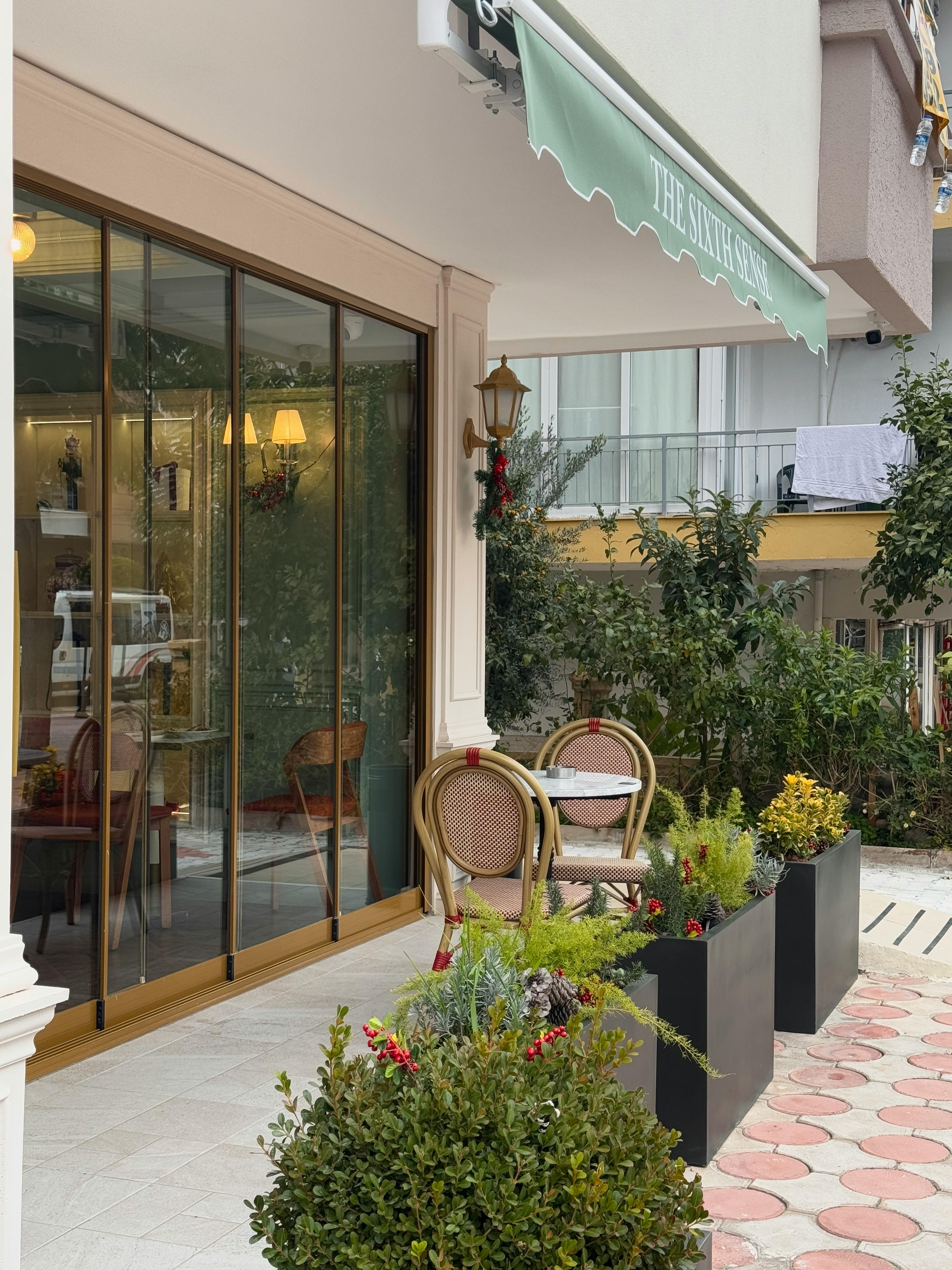 Charming Outdoor Cafe Seating with Greenery · Free Stock Photo