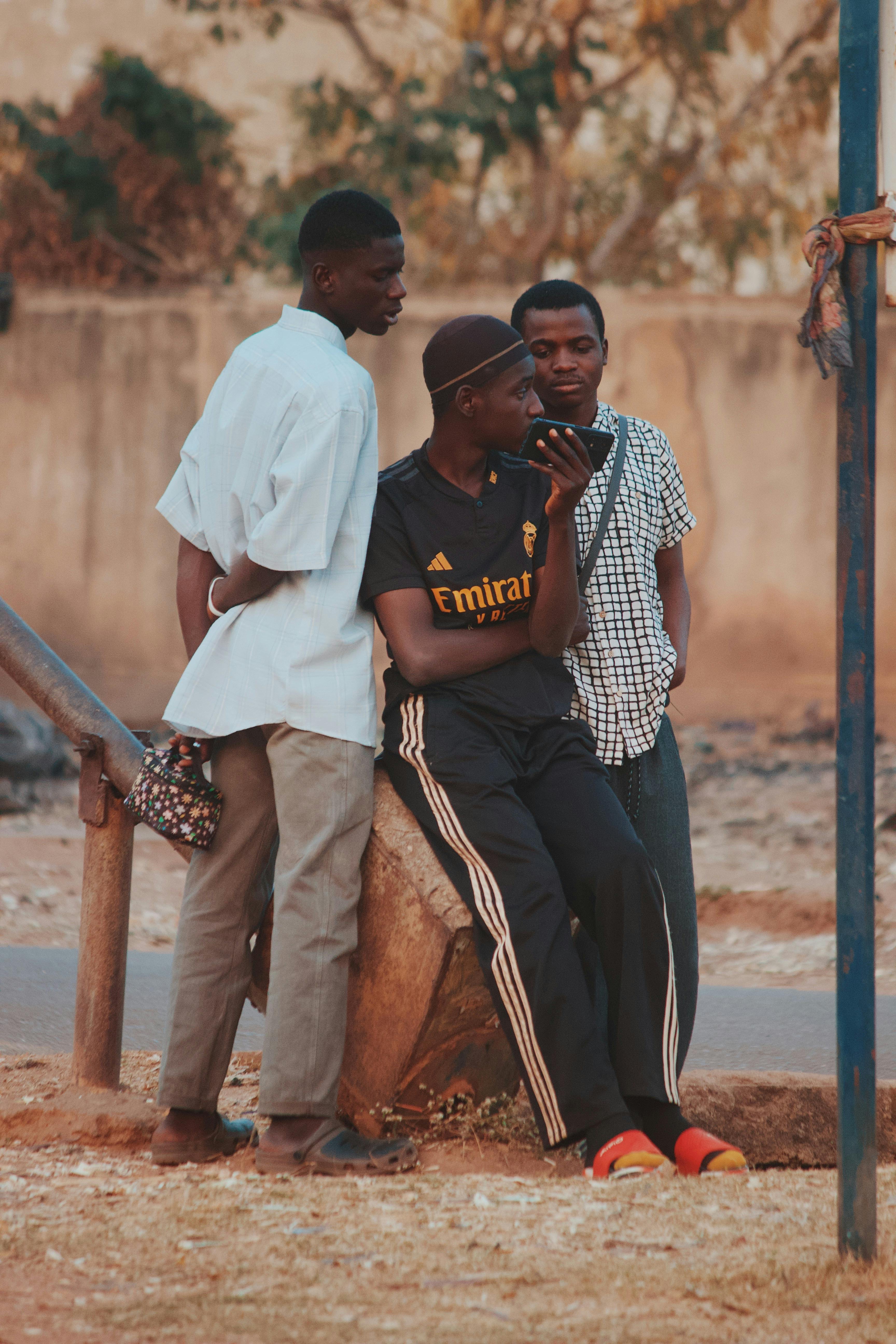 Young Men Socializing Outdoors in Nigeria · Free Stock Photo