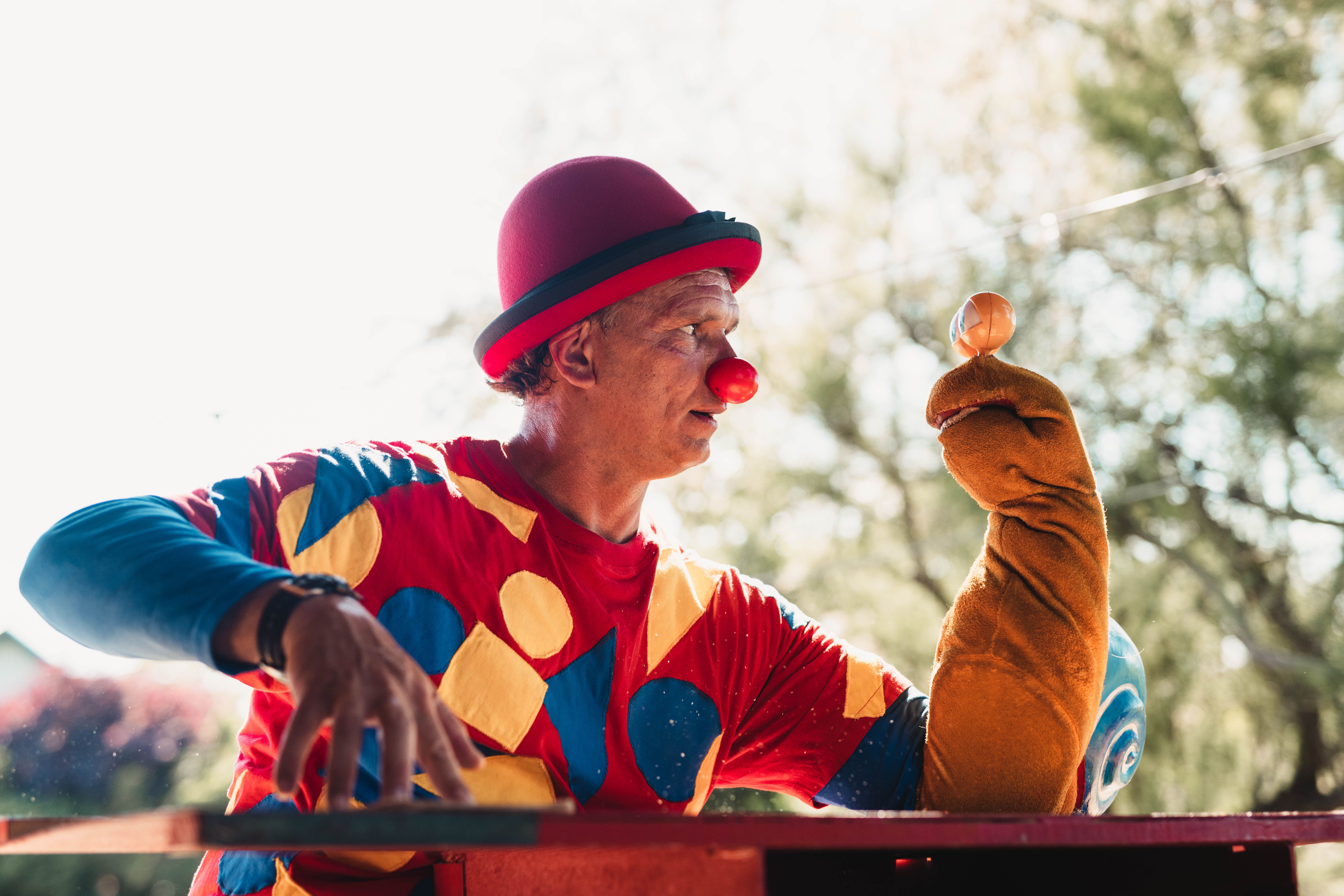 Colorful Clown Performing Puppet Show Outdoors · Free Stock Photo