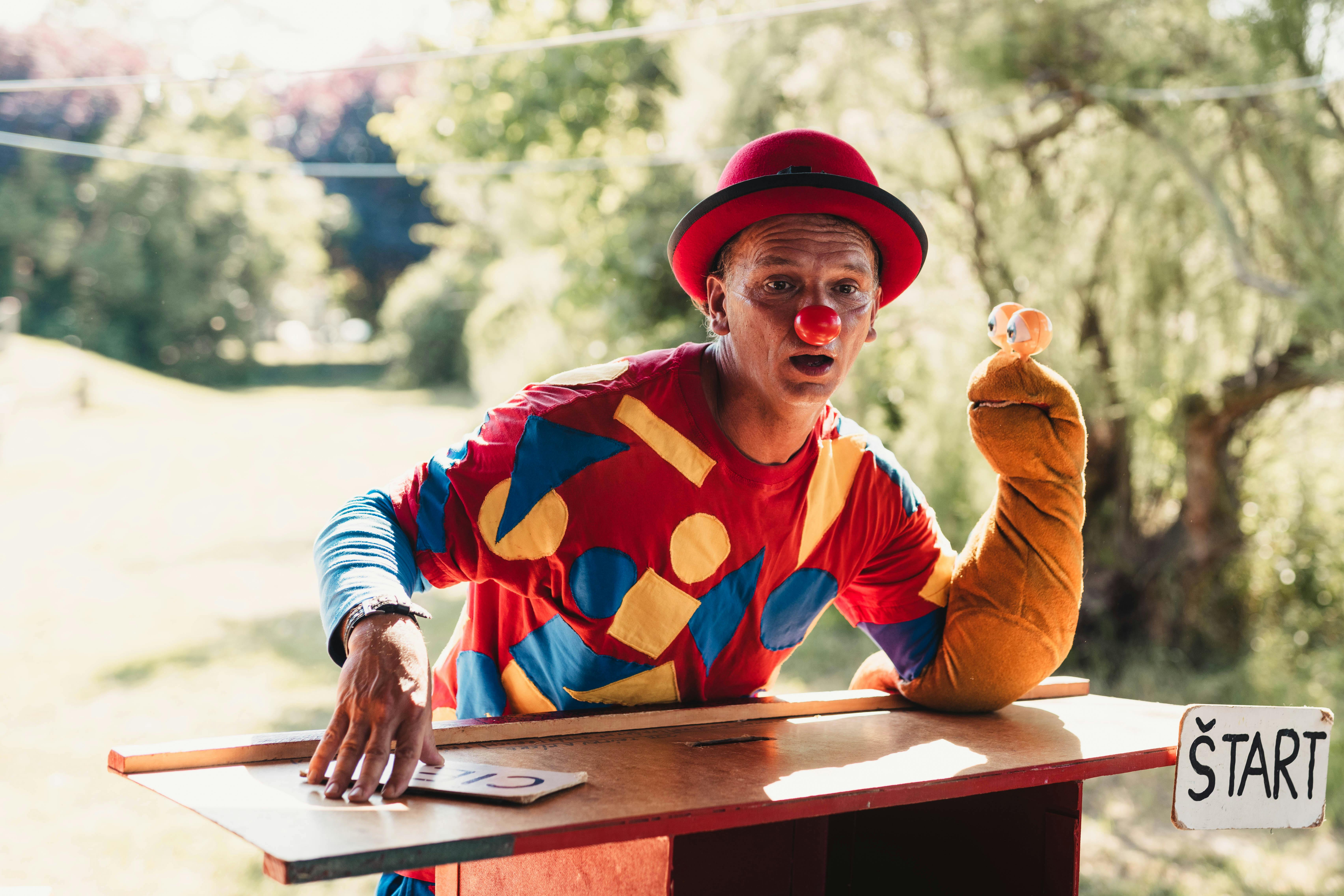 Colorful Clown Performing Puppet Show Outdoors · Free Stock Photo