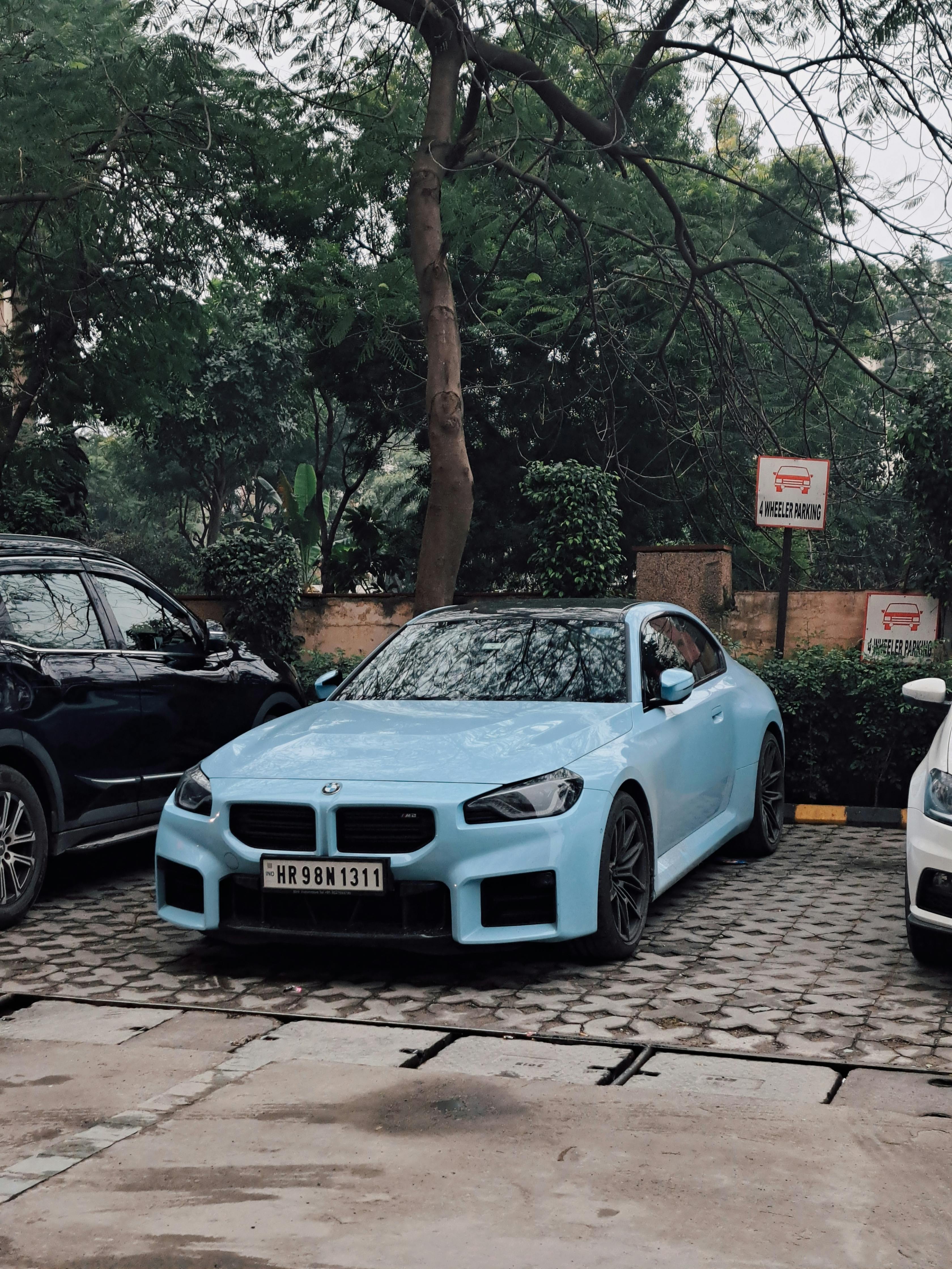 Sky Blue Car Parked Outdoors in Lush Area · Free Stock Photo