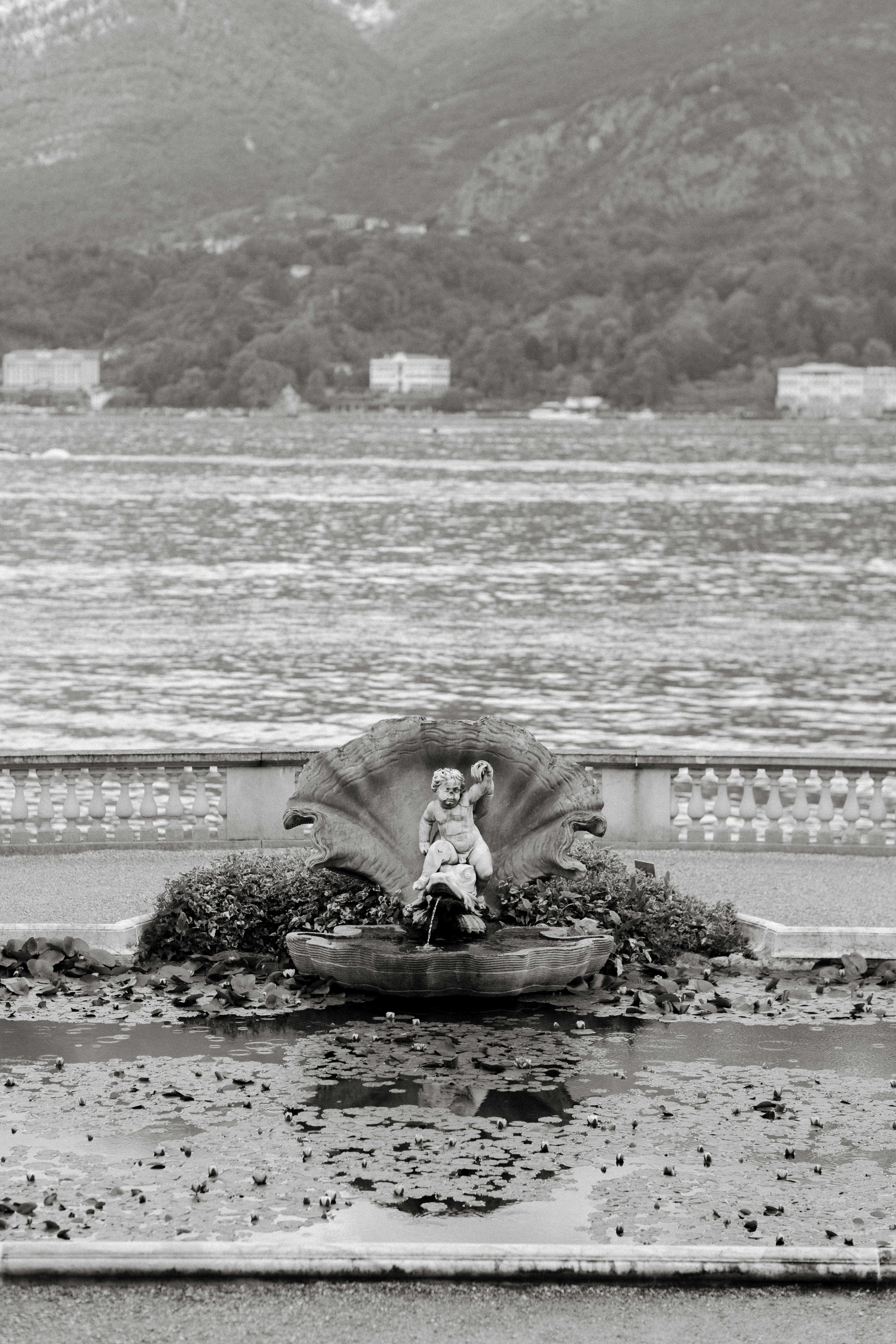 Vintage statue by serene lakeside backdrop · Free Stock Photo