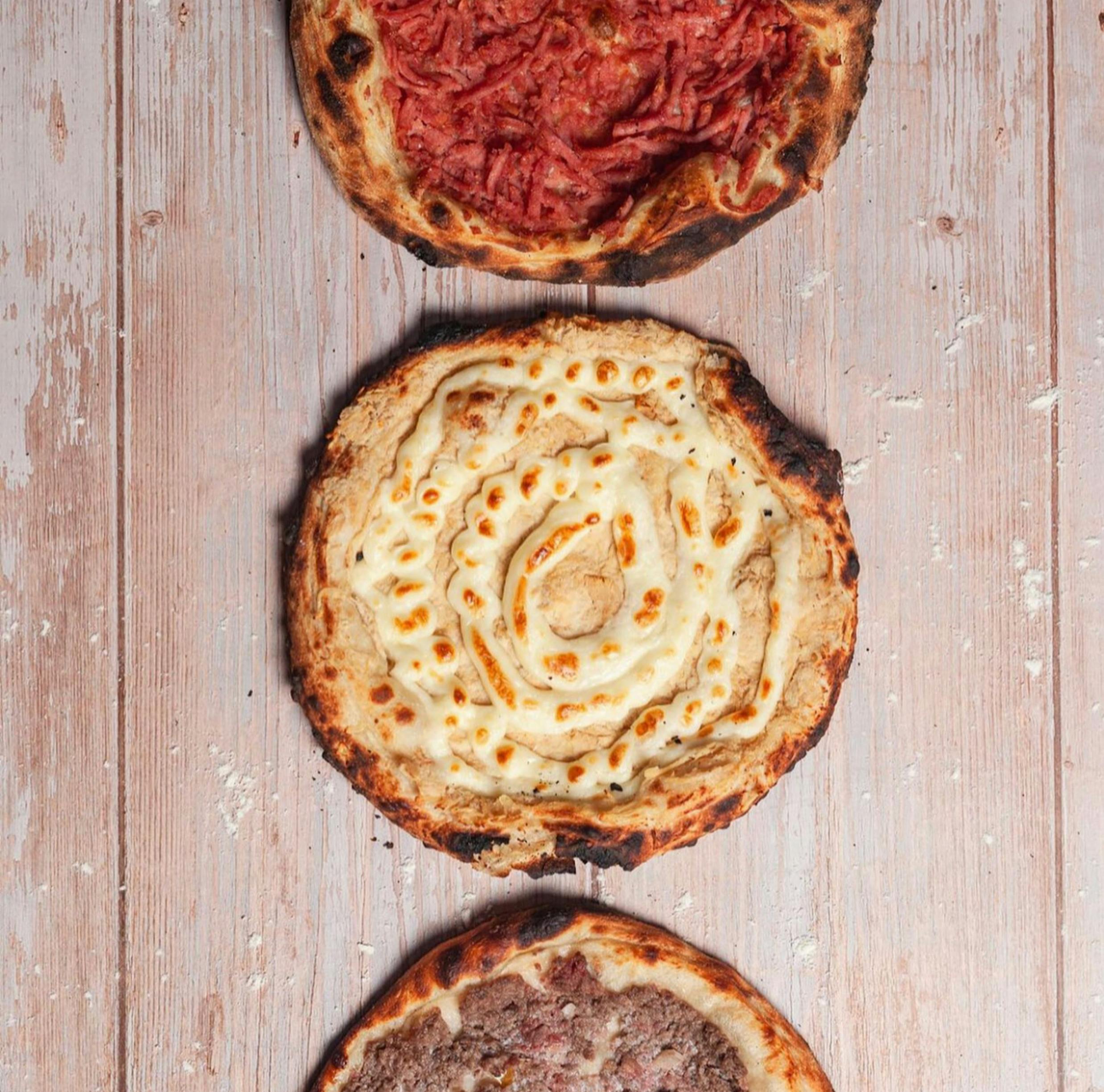 Three Assorted Pizzas on Rustic Surface · Free Stock Photo