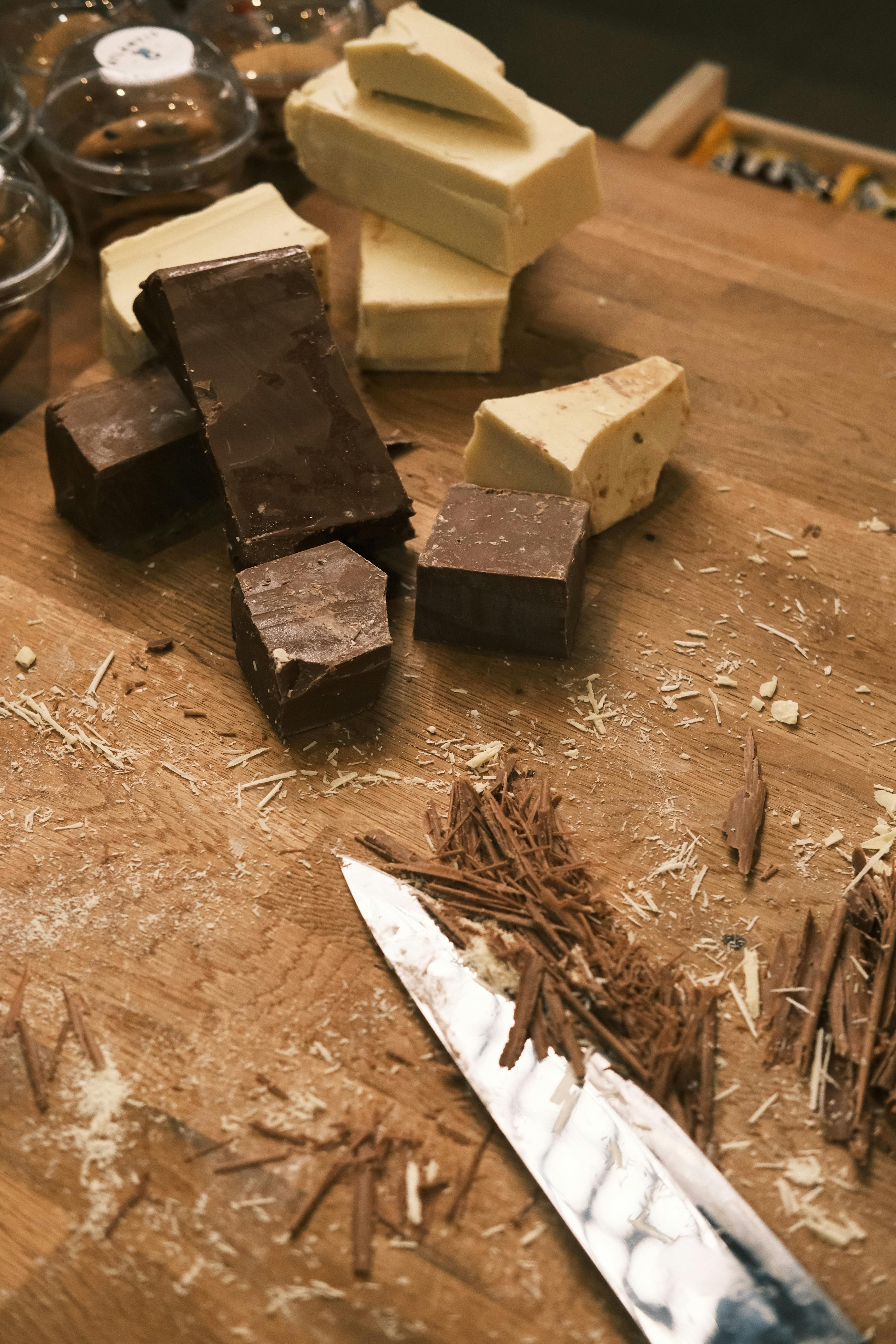 Assorted Chocolate Blocks and Shavings on Wooden Counter · Free Stock Photo