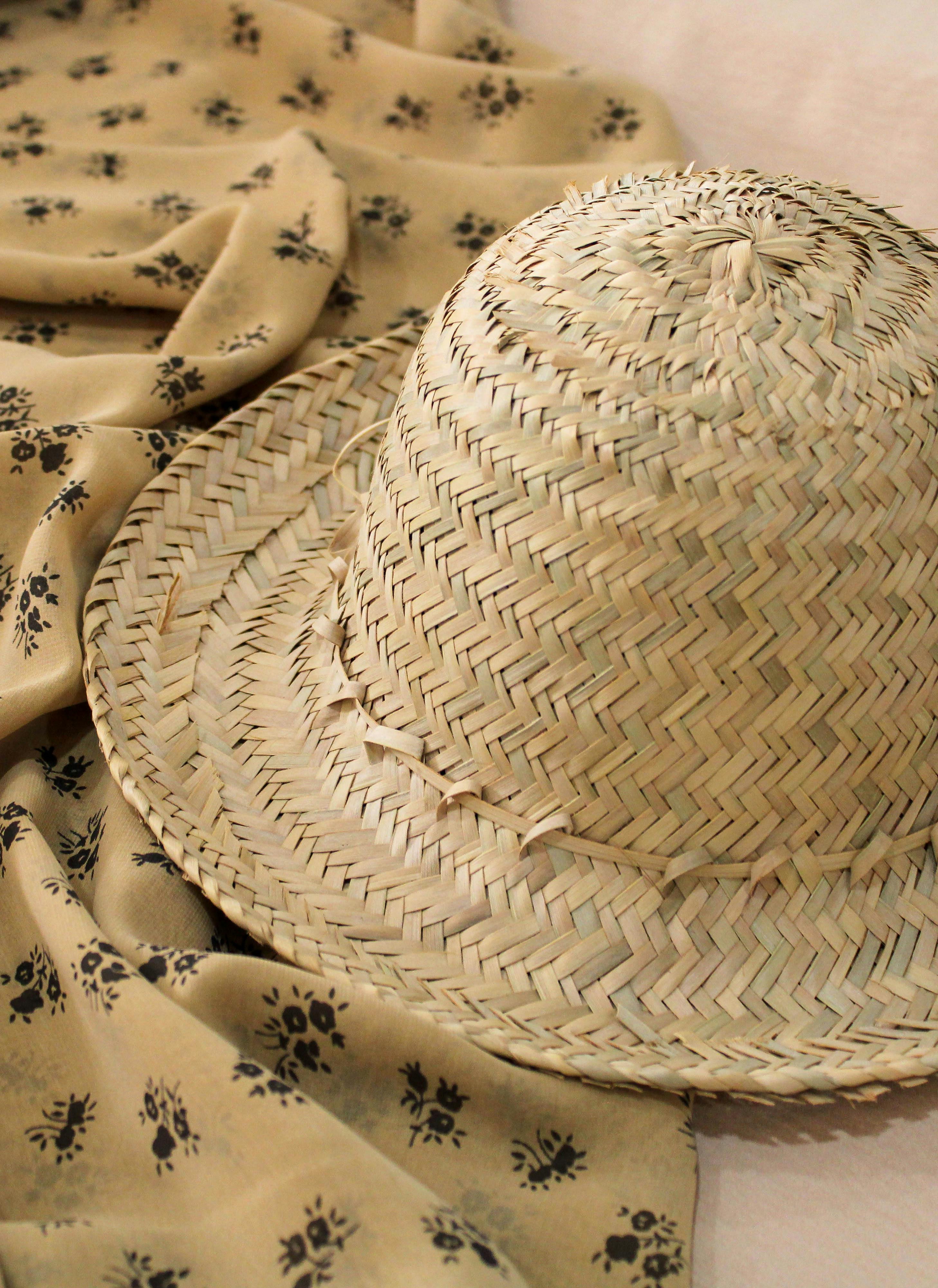 Rustic Straw Hat on Patterned Fabric · Free Stock Photo
