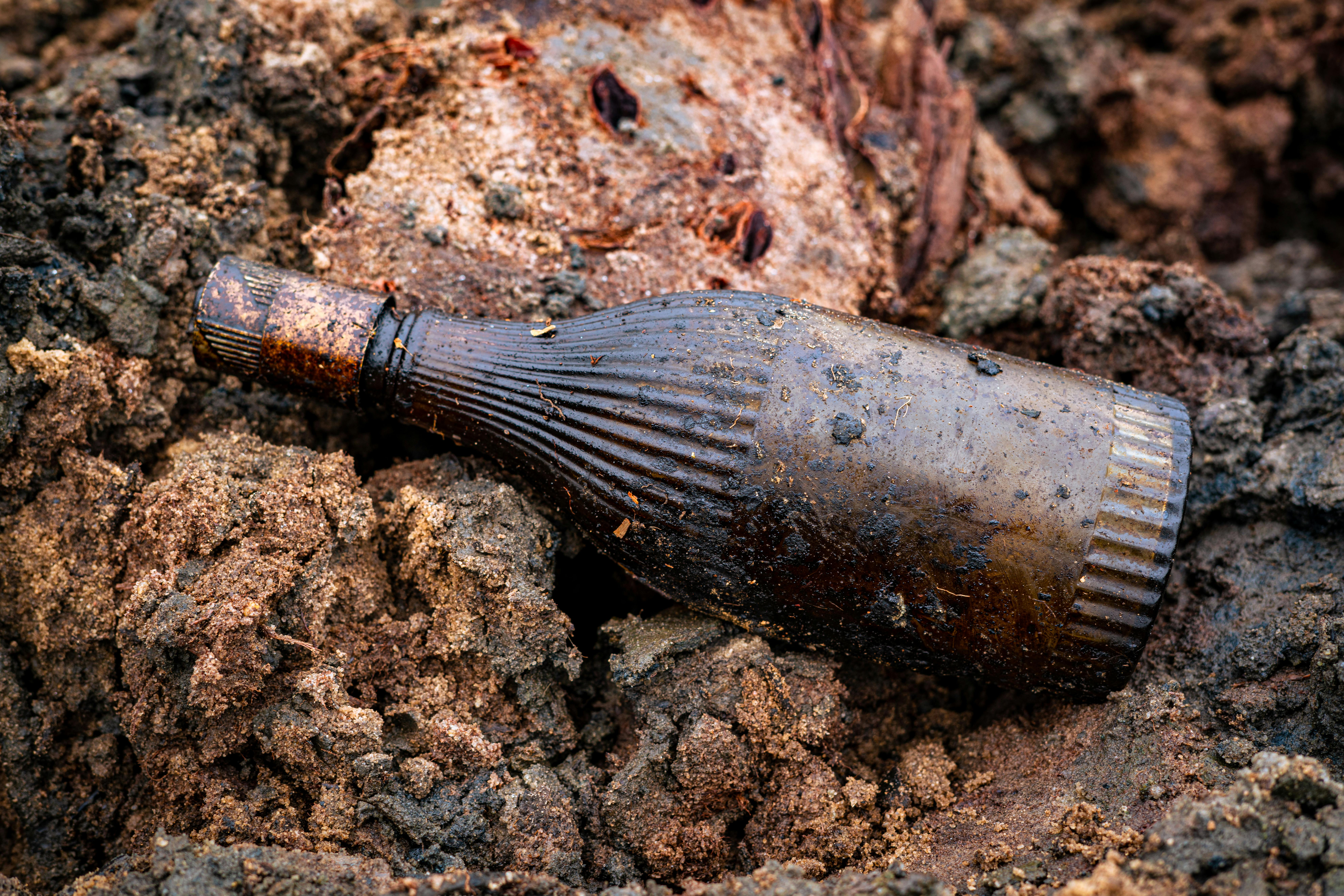 Discarded Bottle in Nigerian Soil Highlights Pollution · Free Stock Photo