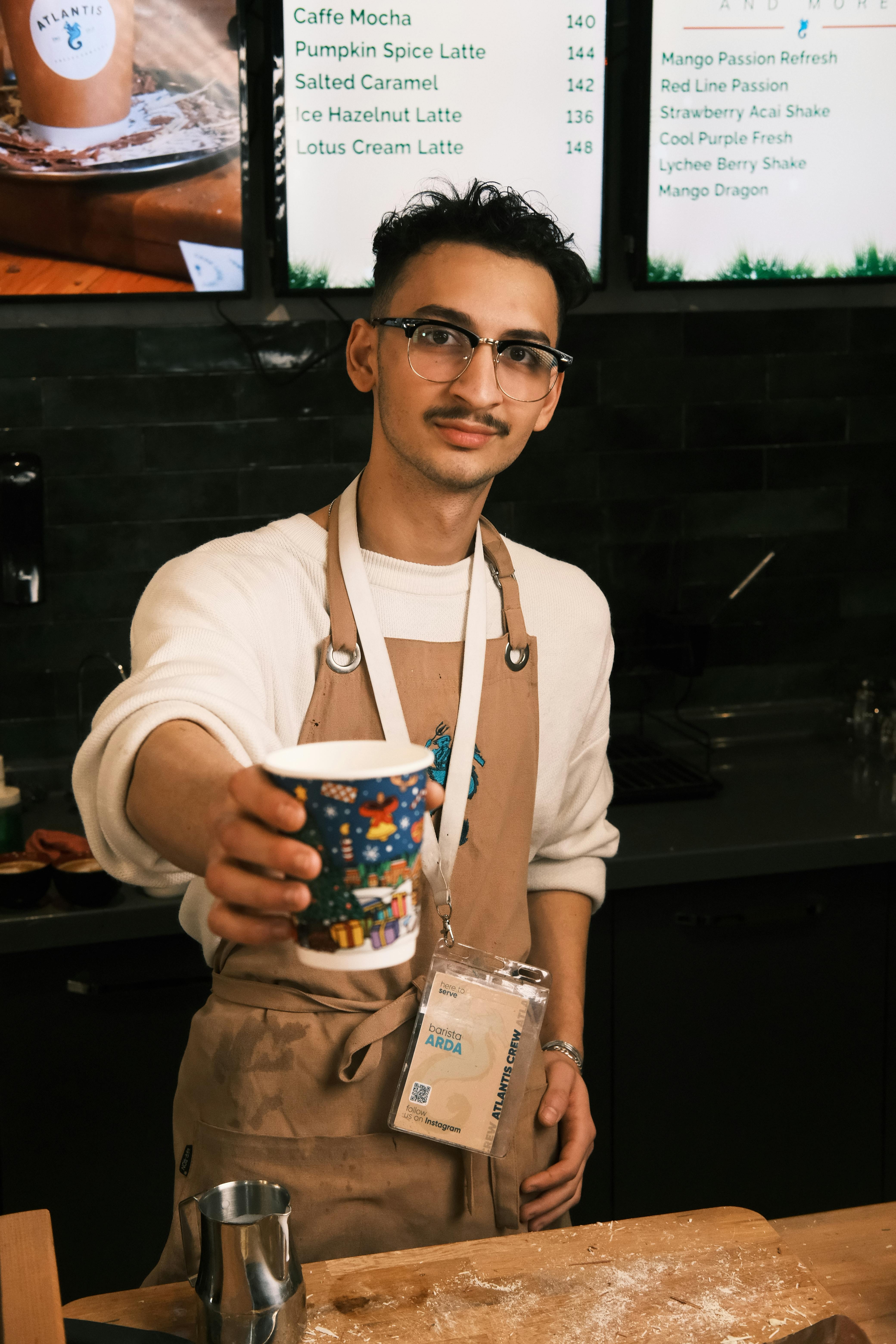 Barista Serving Coffee in a Modern Café Setting · Free Stock Photo