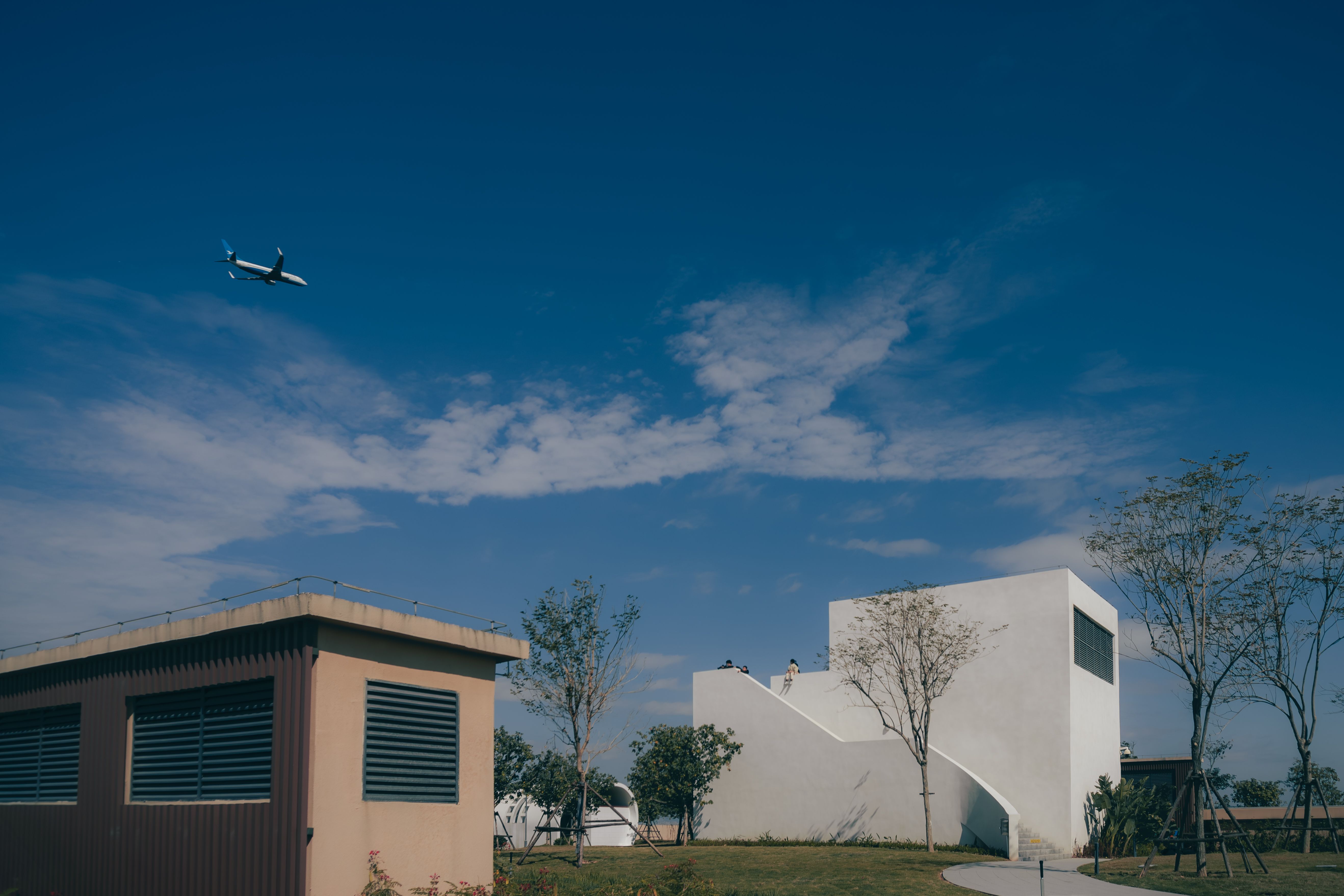 Modern Architecture and Airplane Under Blue Sky · Free Stock Photo