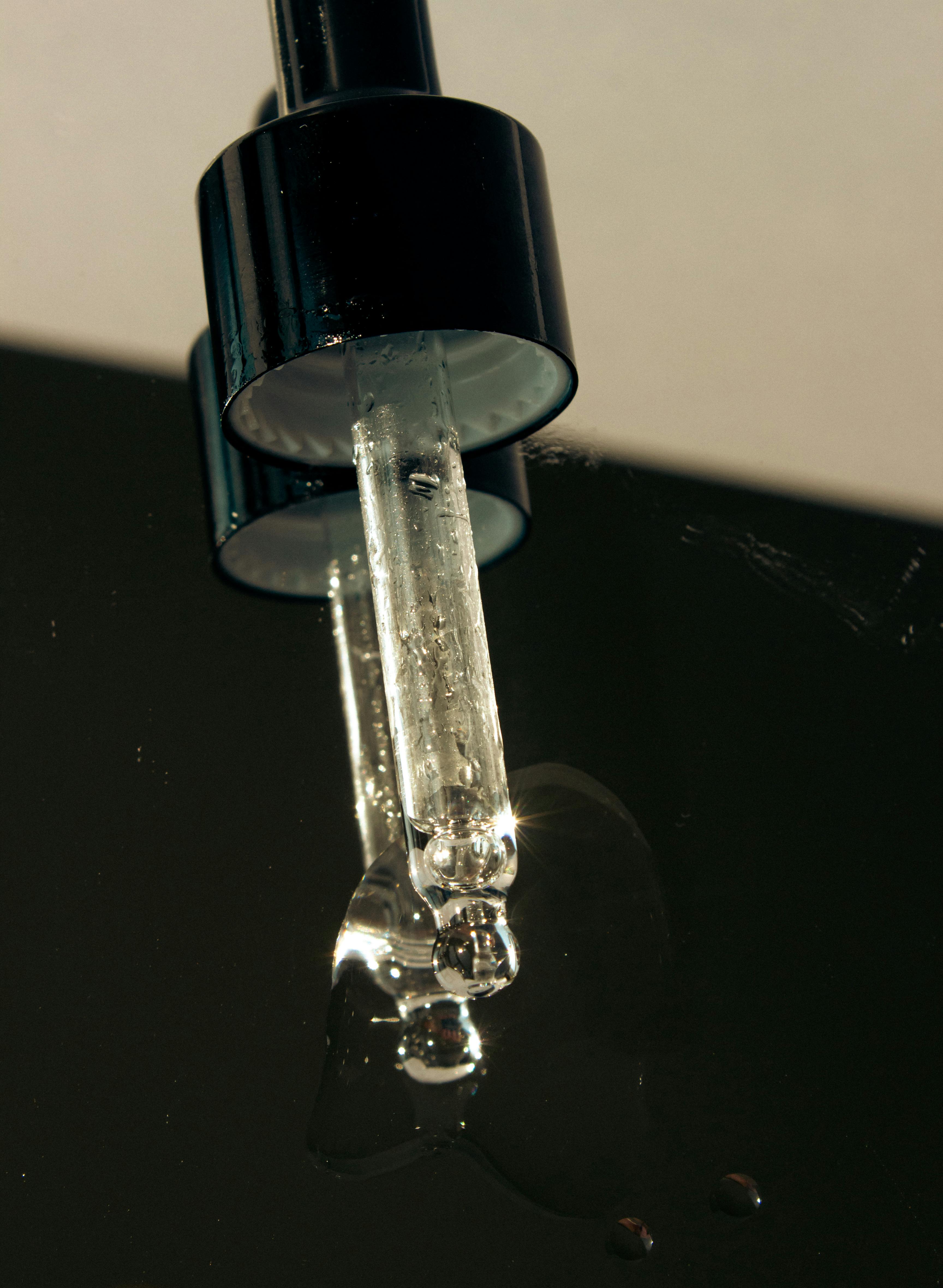 Close-up of Liquid Dropper with Reflective Surface · Free Stock Photo