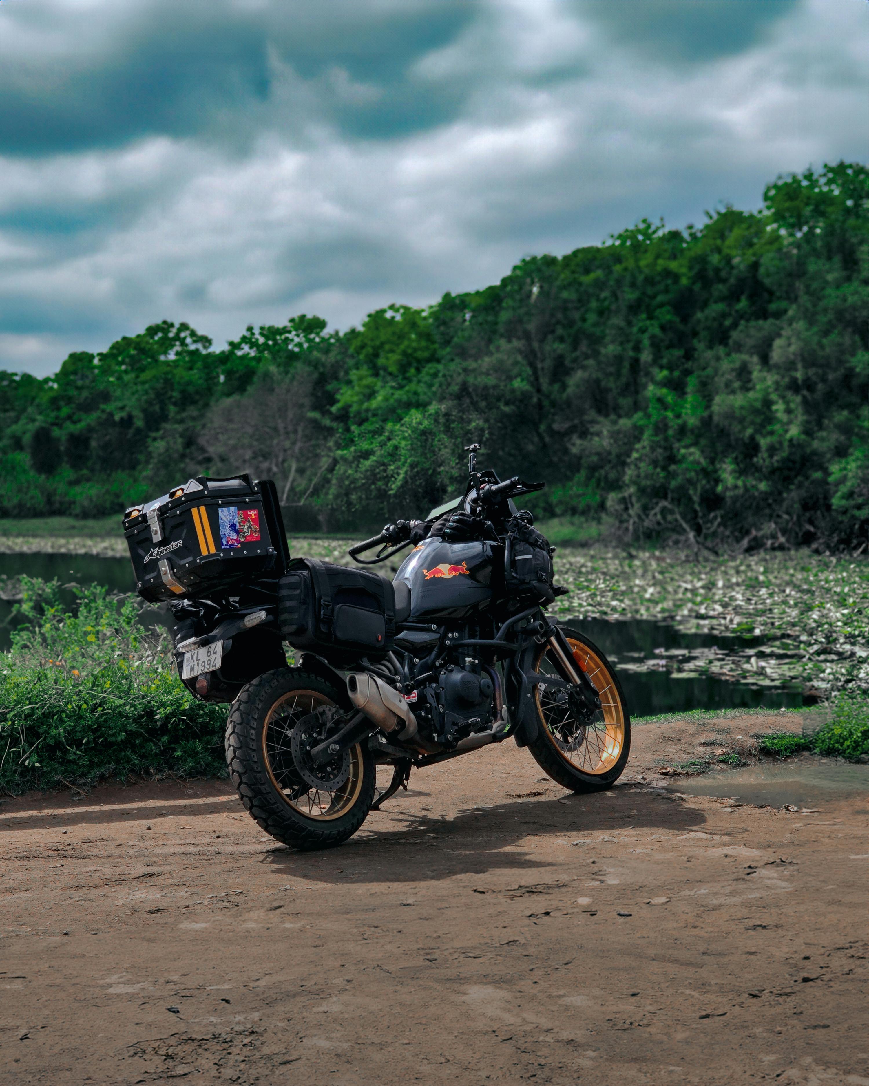 Adventure Motorcycle by Scenic River Under Dramatic Sky · Free Stock Photo