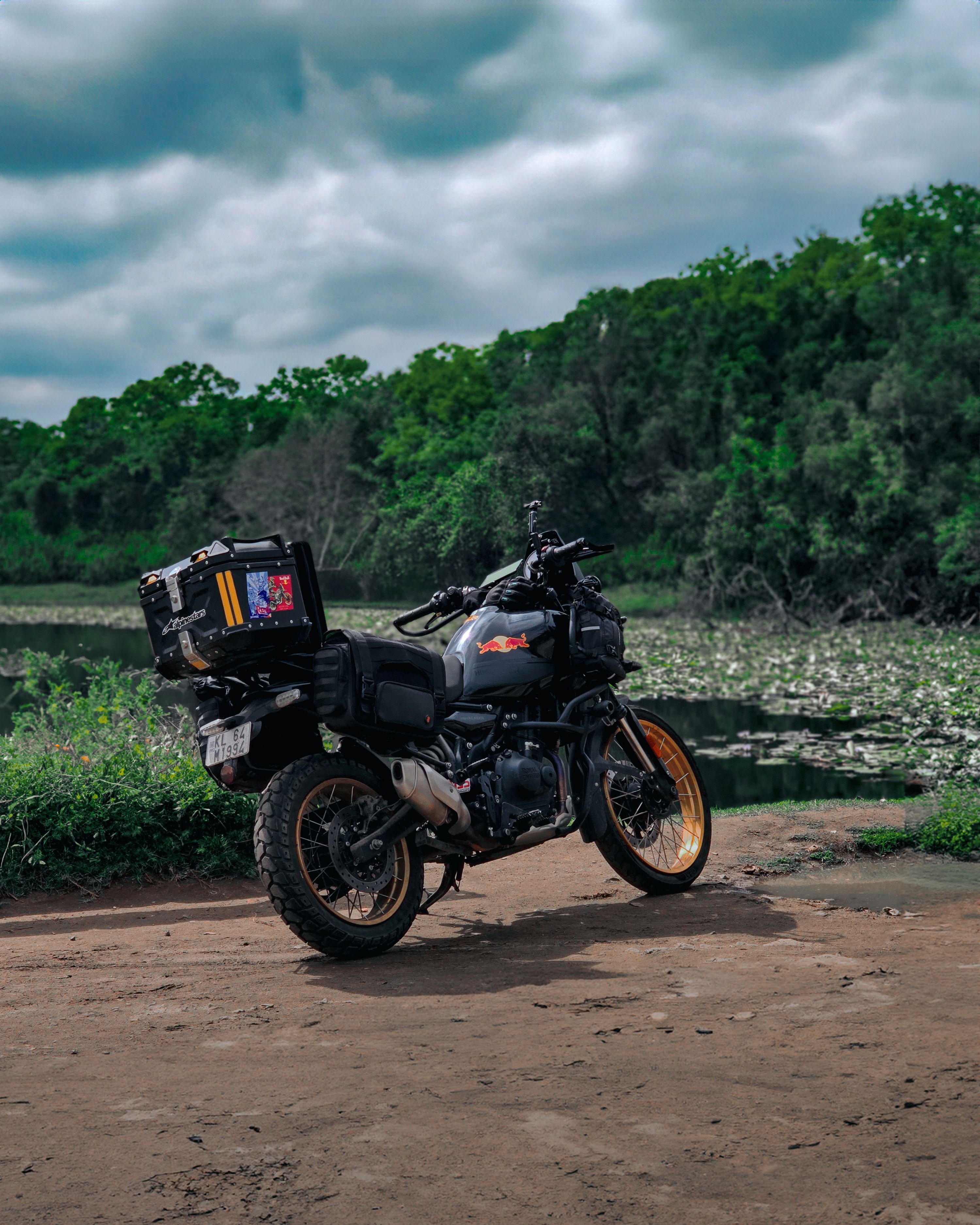 Adventure Motorcycle by Scenic River Under Dramatic Sky · Free Stock Photo