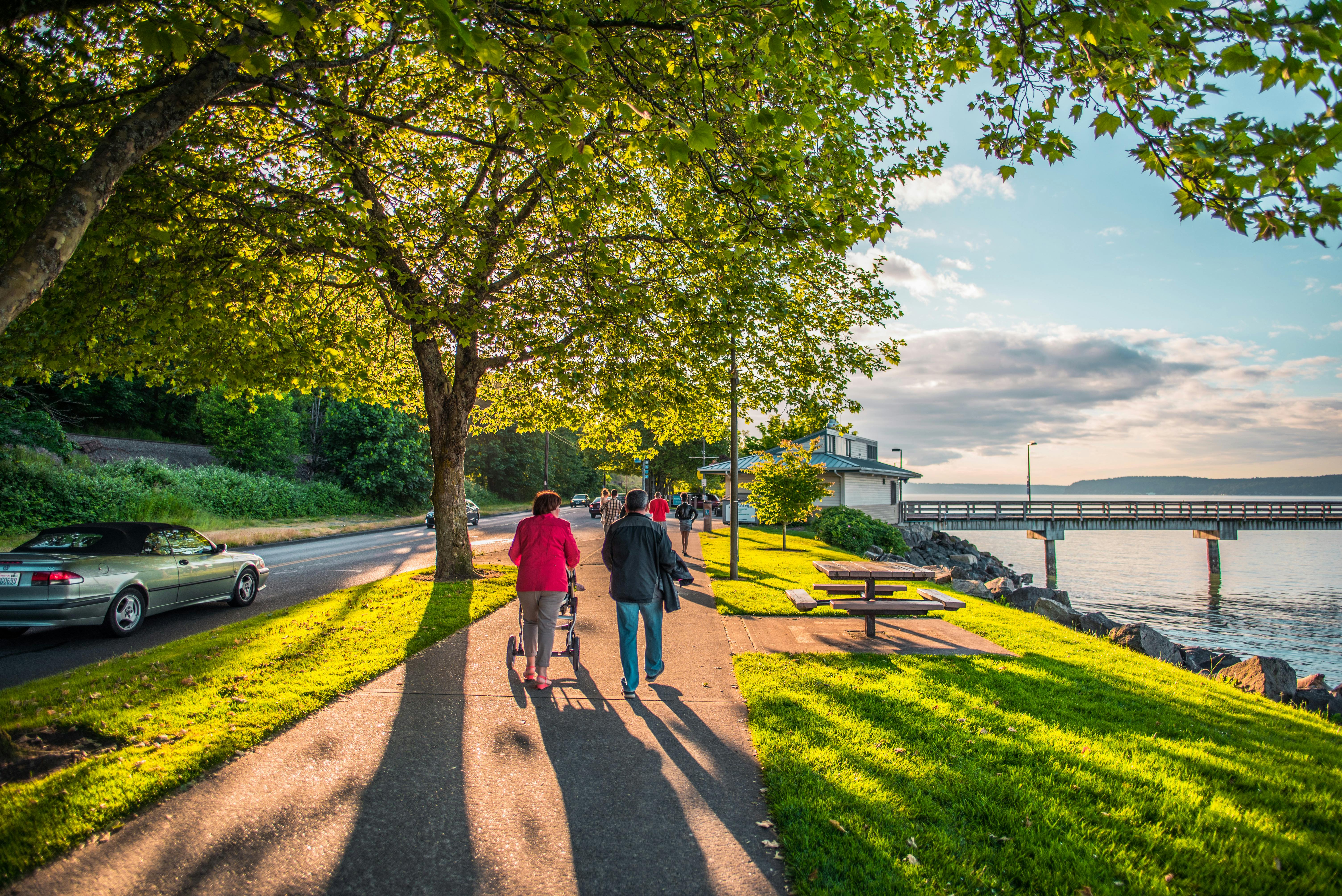 Scenic Riverside Walkway with People Strolling · Free Stock Photo