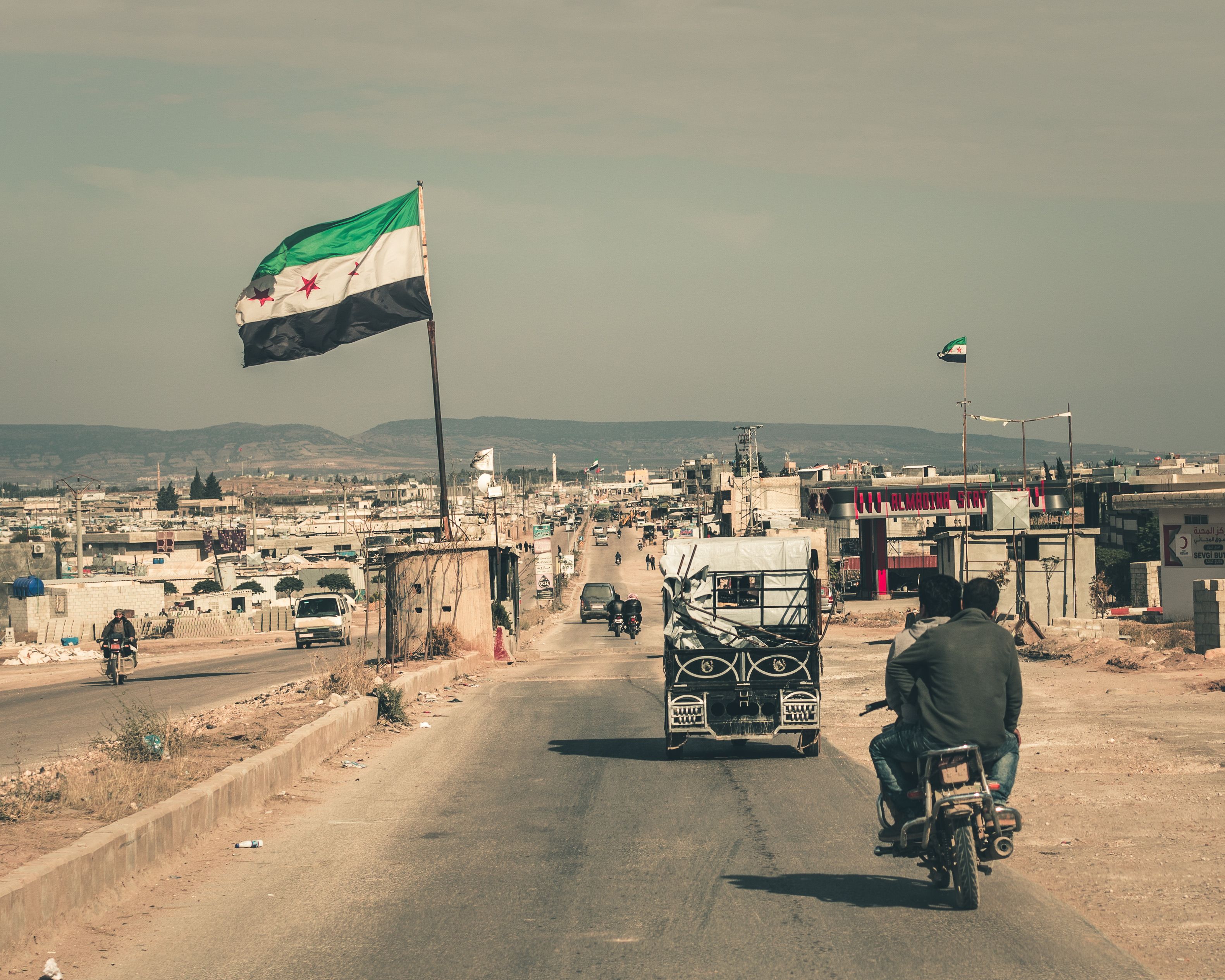 Street scene with flag and vehicles in Middle Eastern town · Free Stock ...