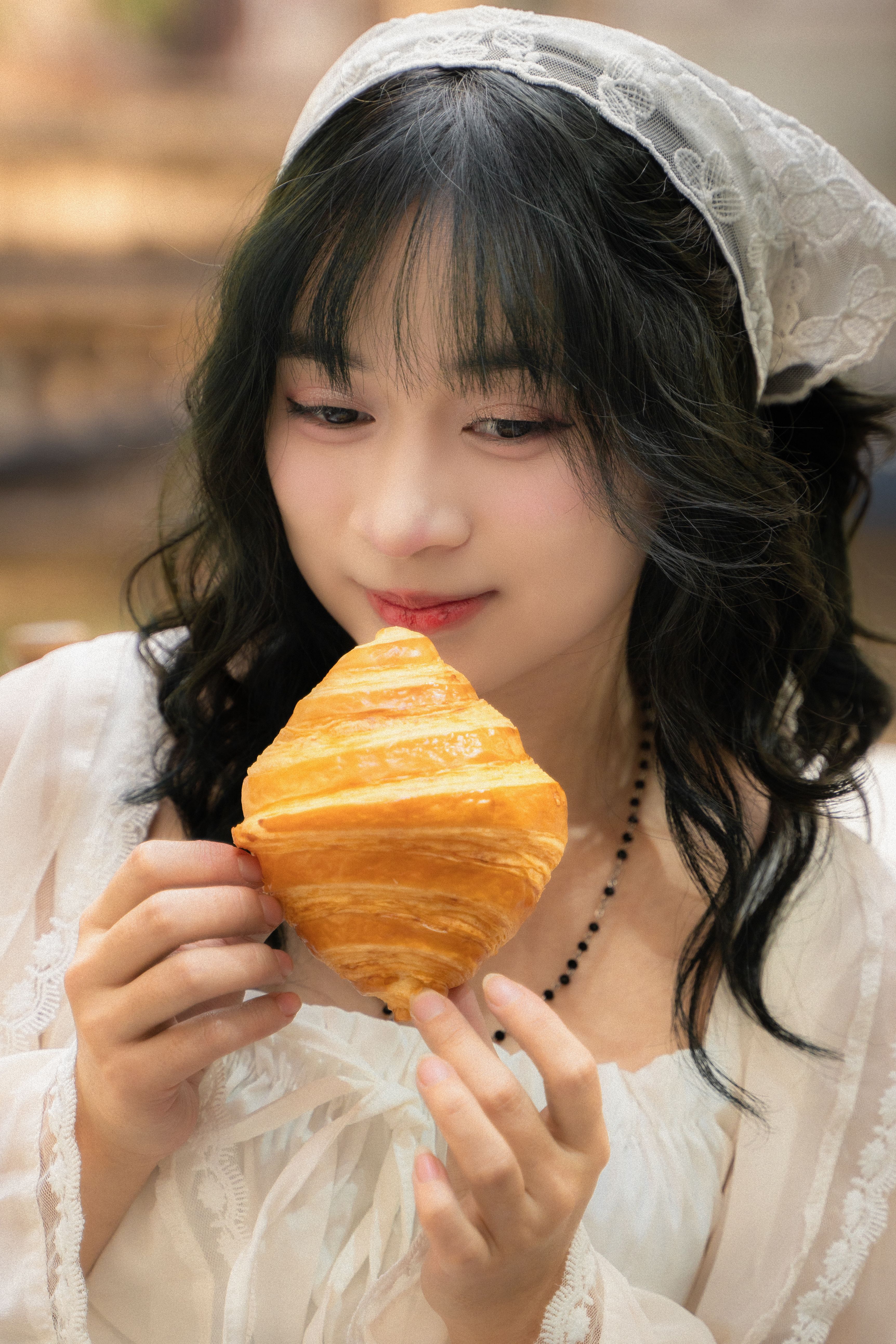 Woman Enjoying a Fresh Croissant Indoors · Free Stock Photo