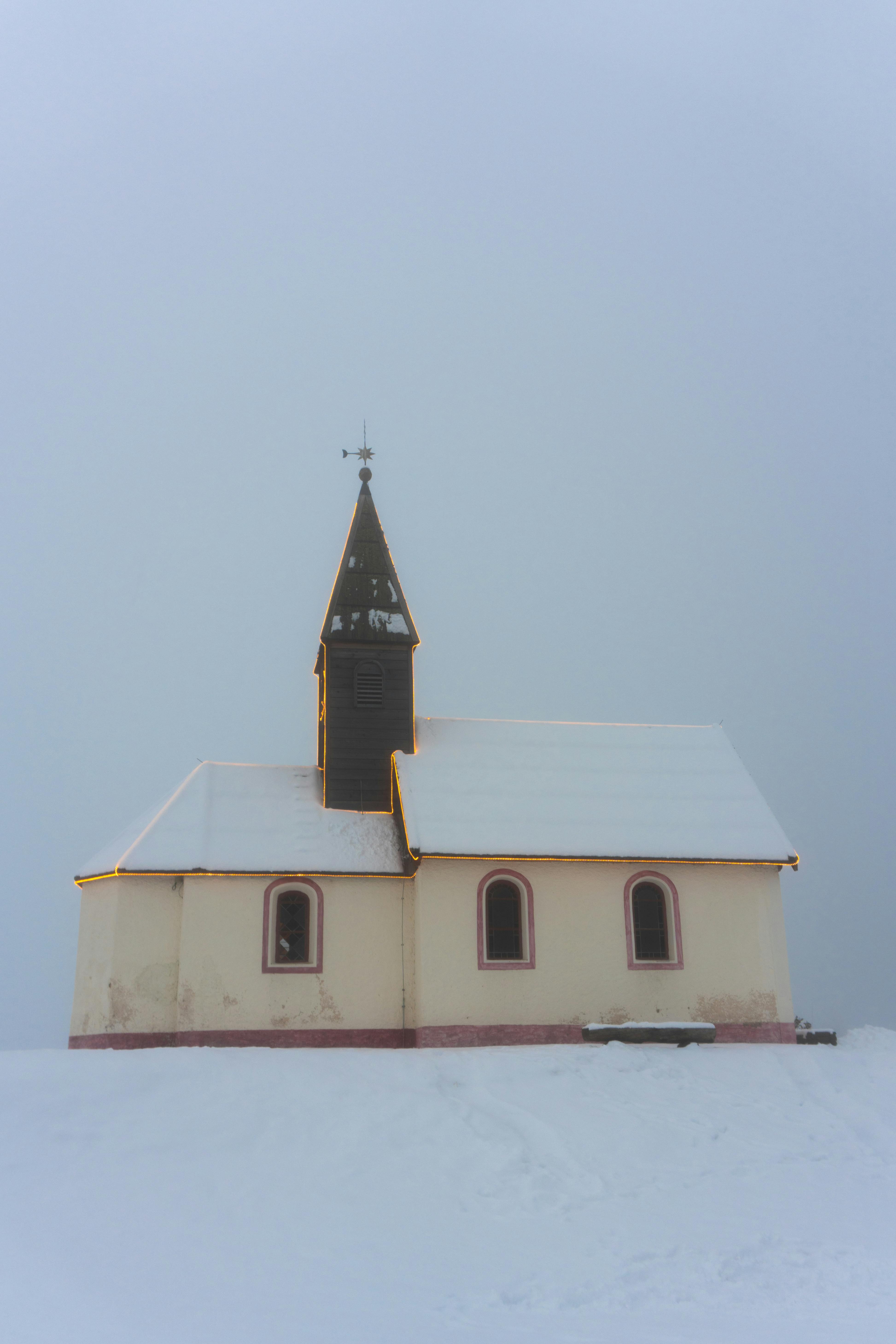 Snow-covered church in foggy winter scene · Free Stock Photo