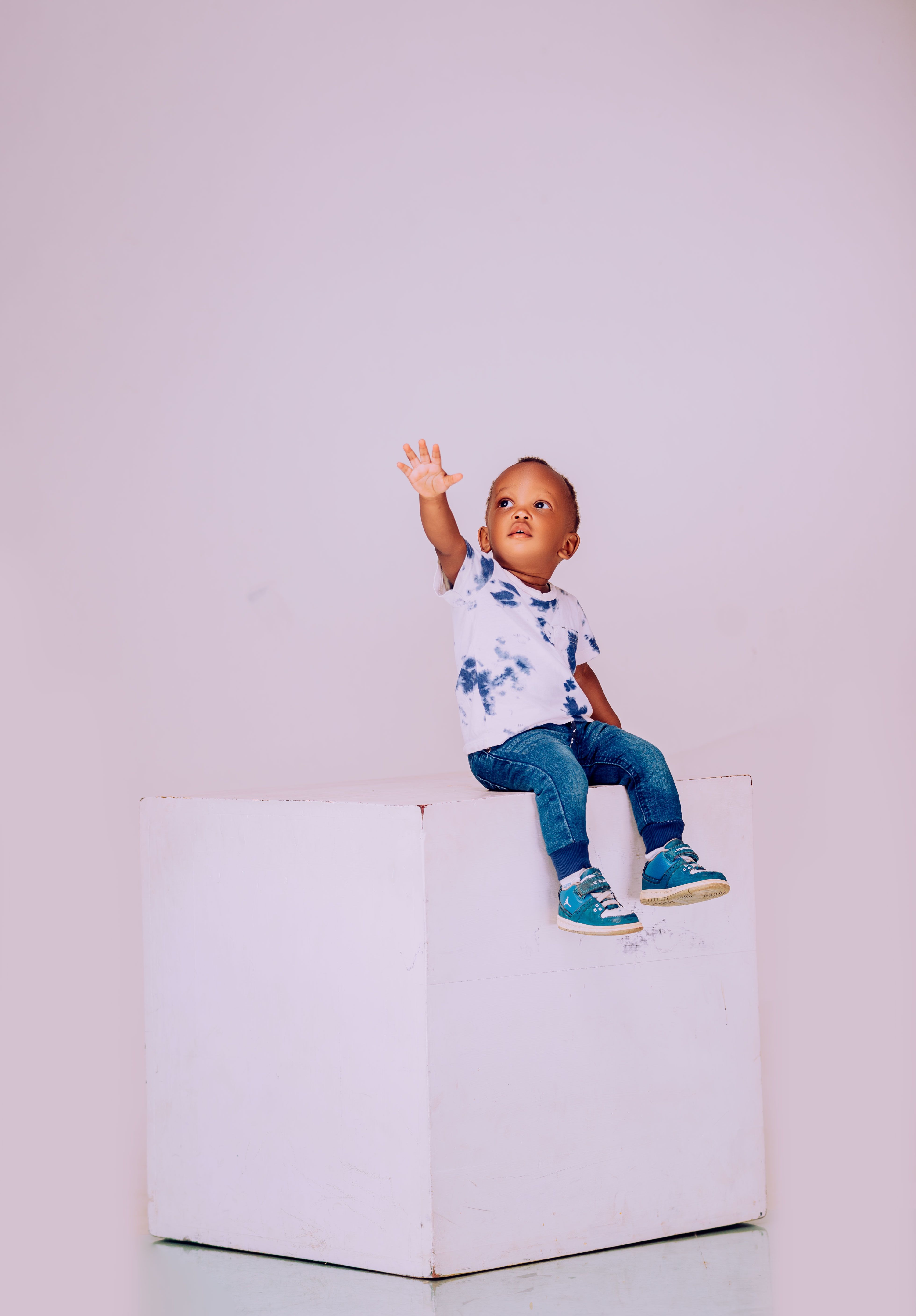 Adorable Toddler Reaching Upward on White Cube · Free Stock Photo