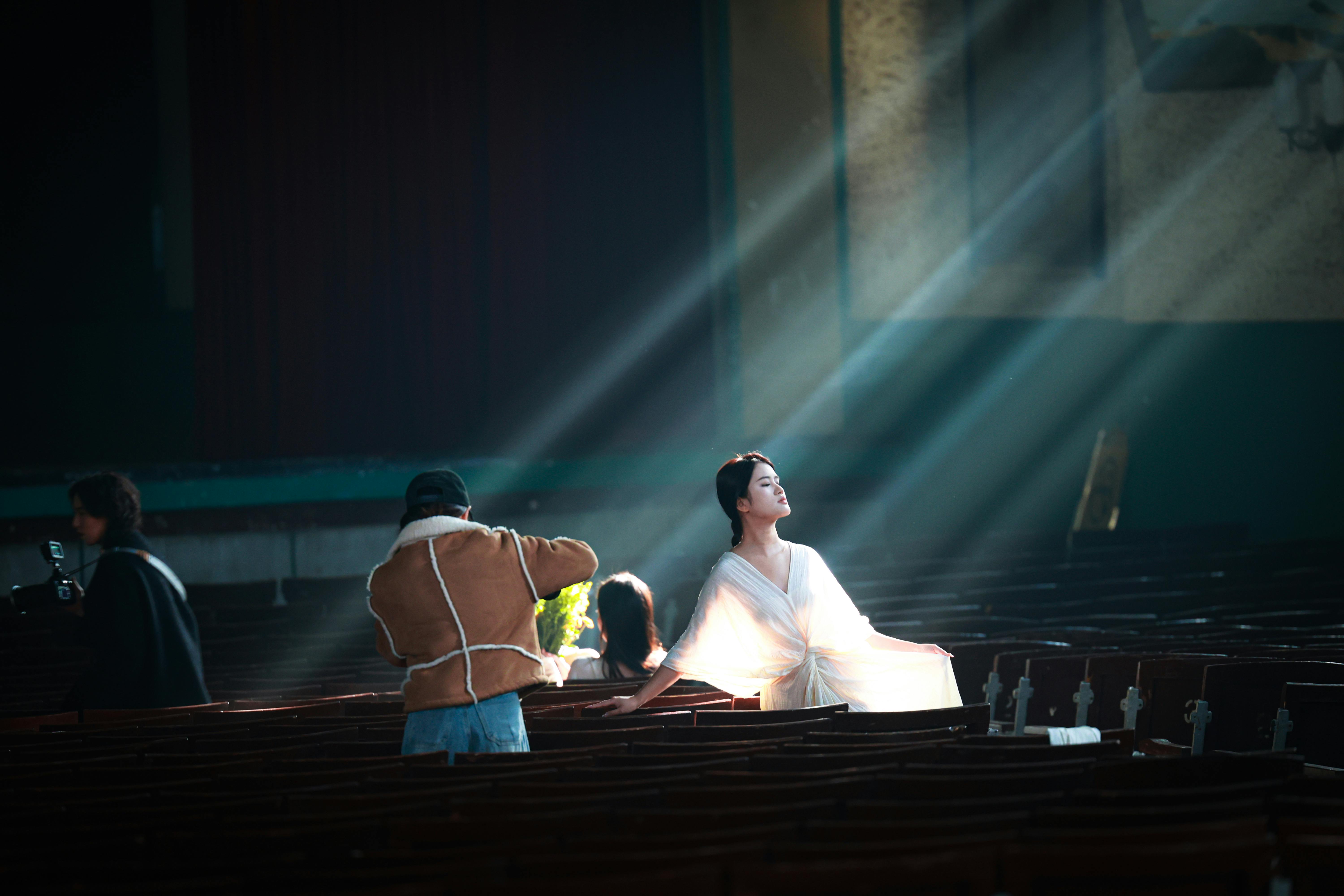 Dramatic Indoor Portrait in Sunlit Theater · Free Stock Photo