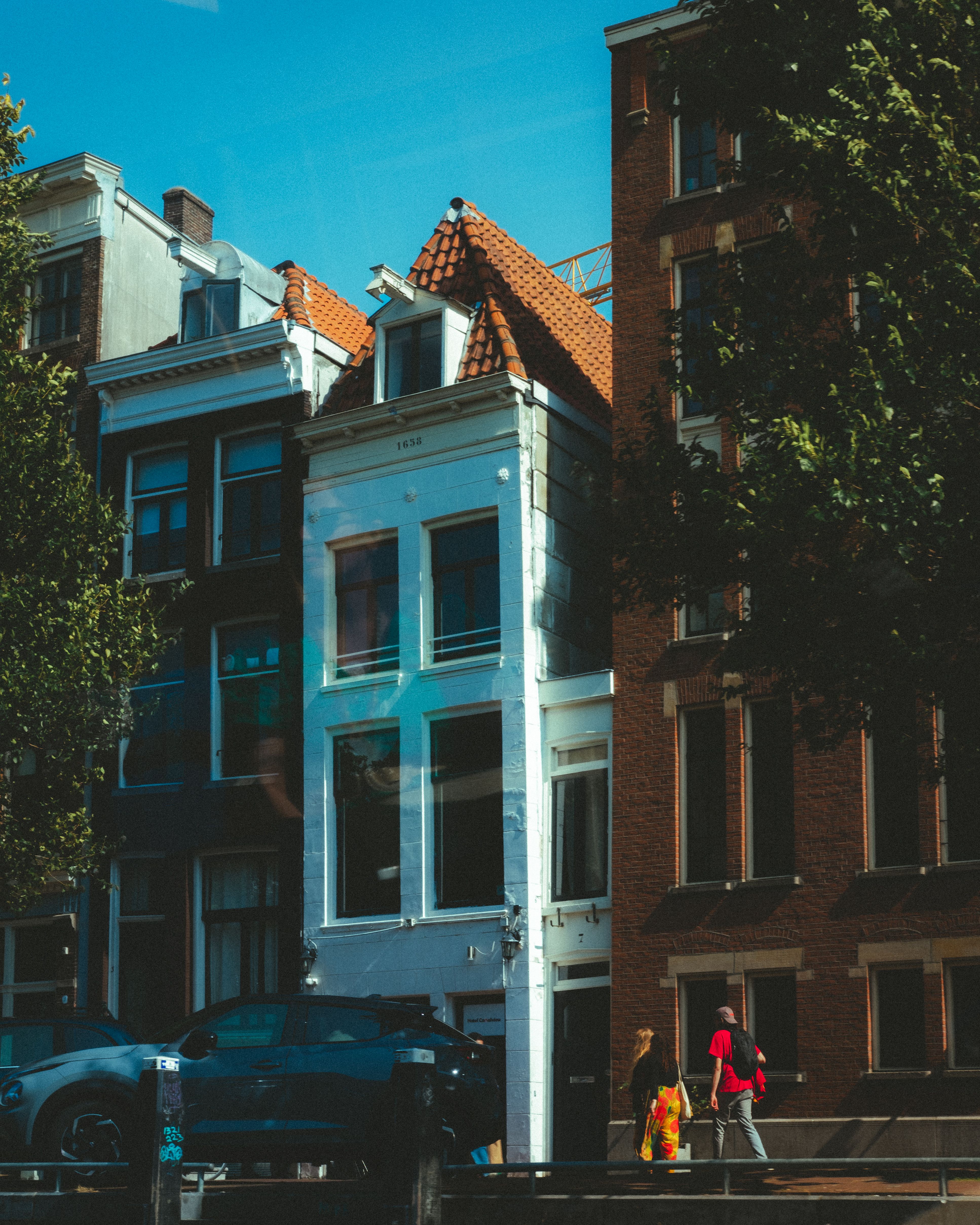 Quaint Amsterdam Canal House With Travelers · Free Stock Photo