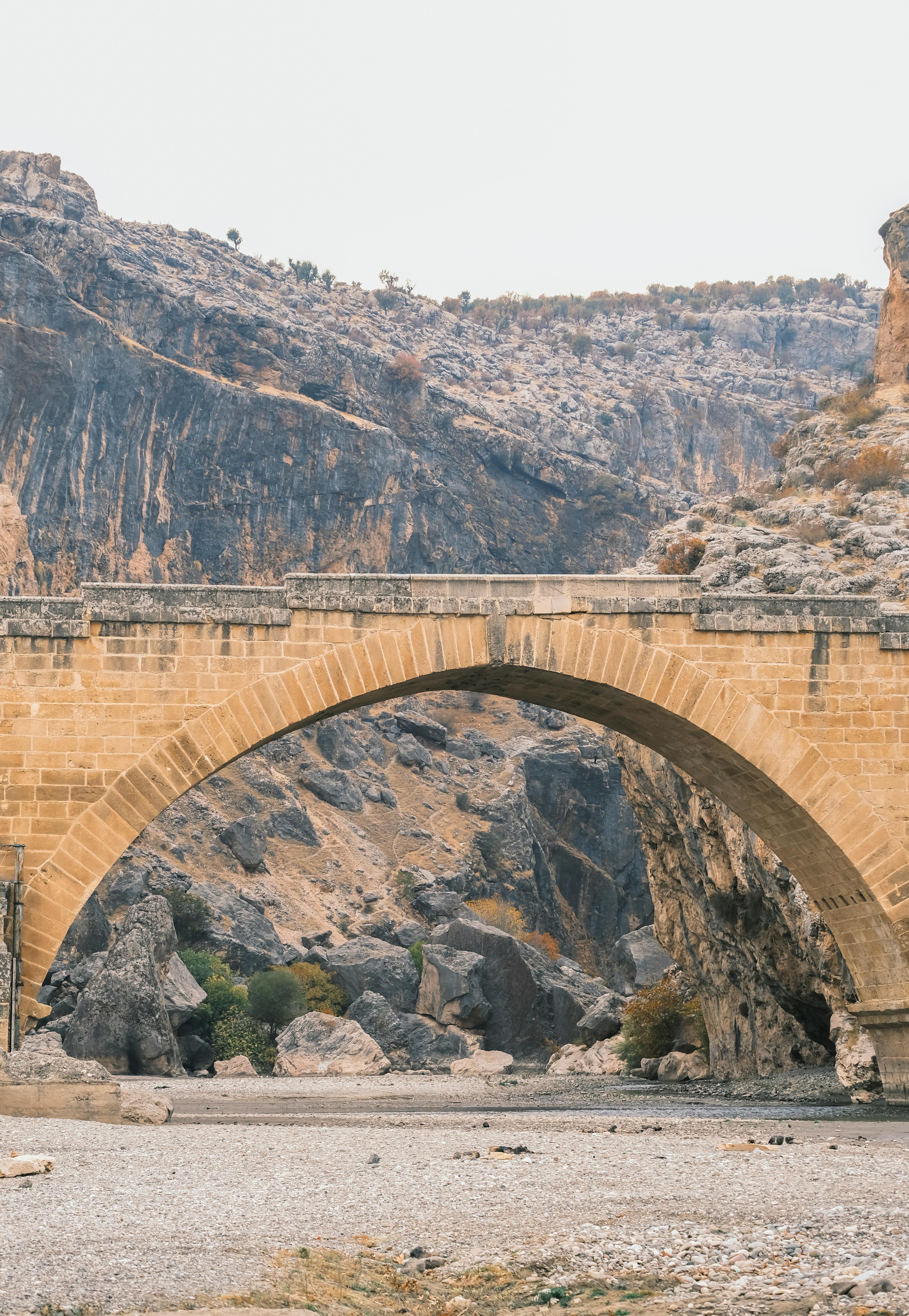 Ancient Stone Bridge in Rugged Mountain Valley · Free Stock Photo