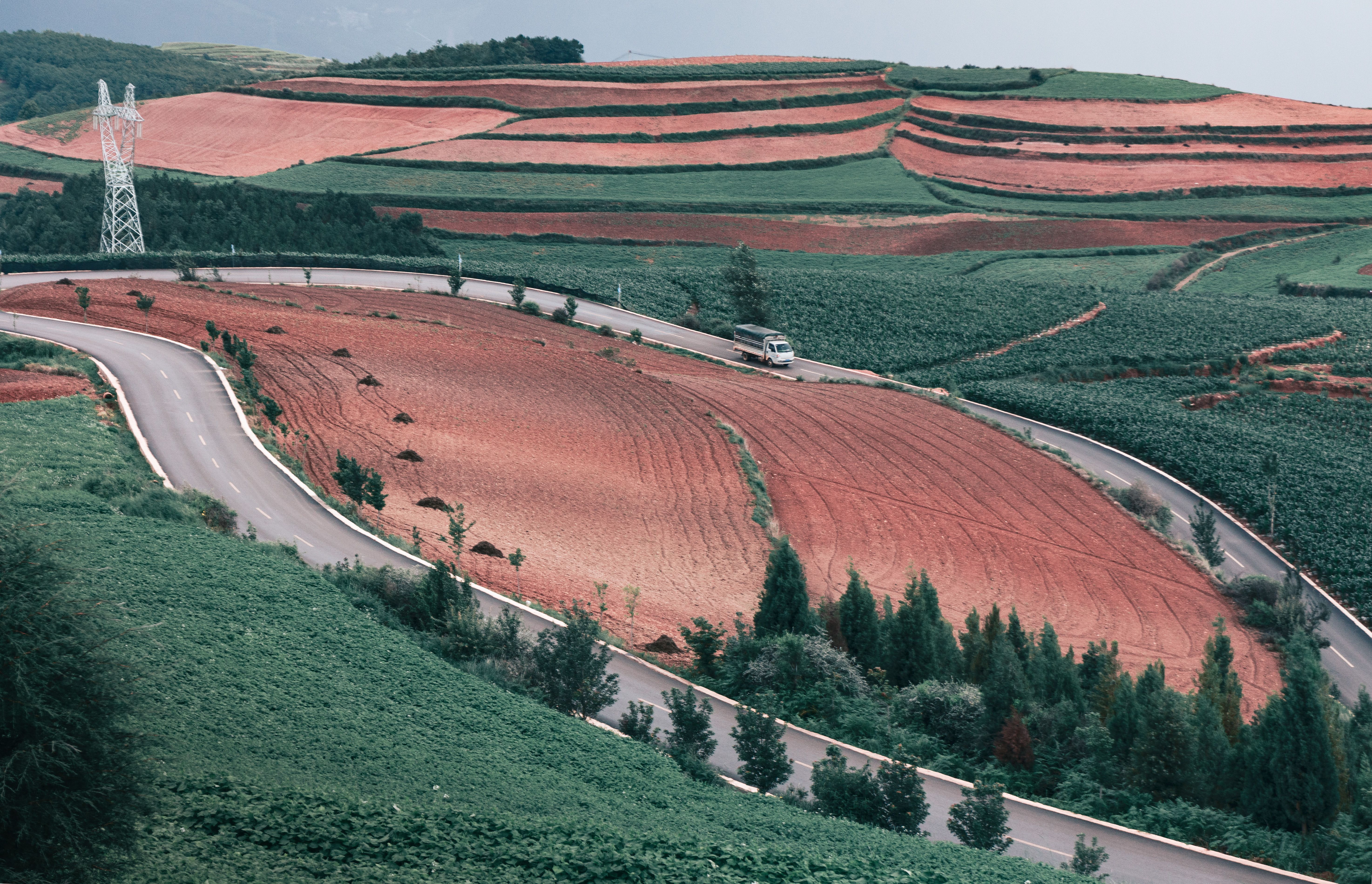 Scenic rural road winding through terraced fields · Free Stock Photo