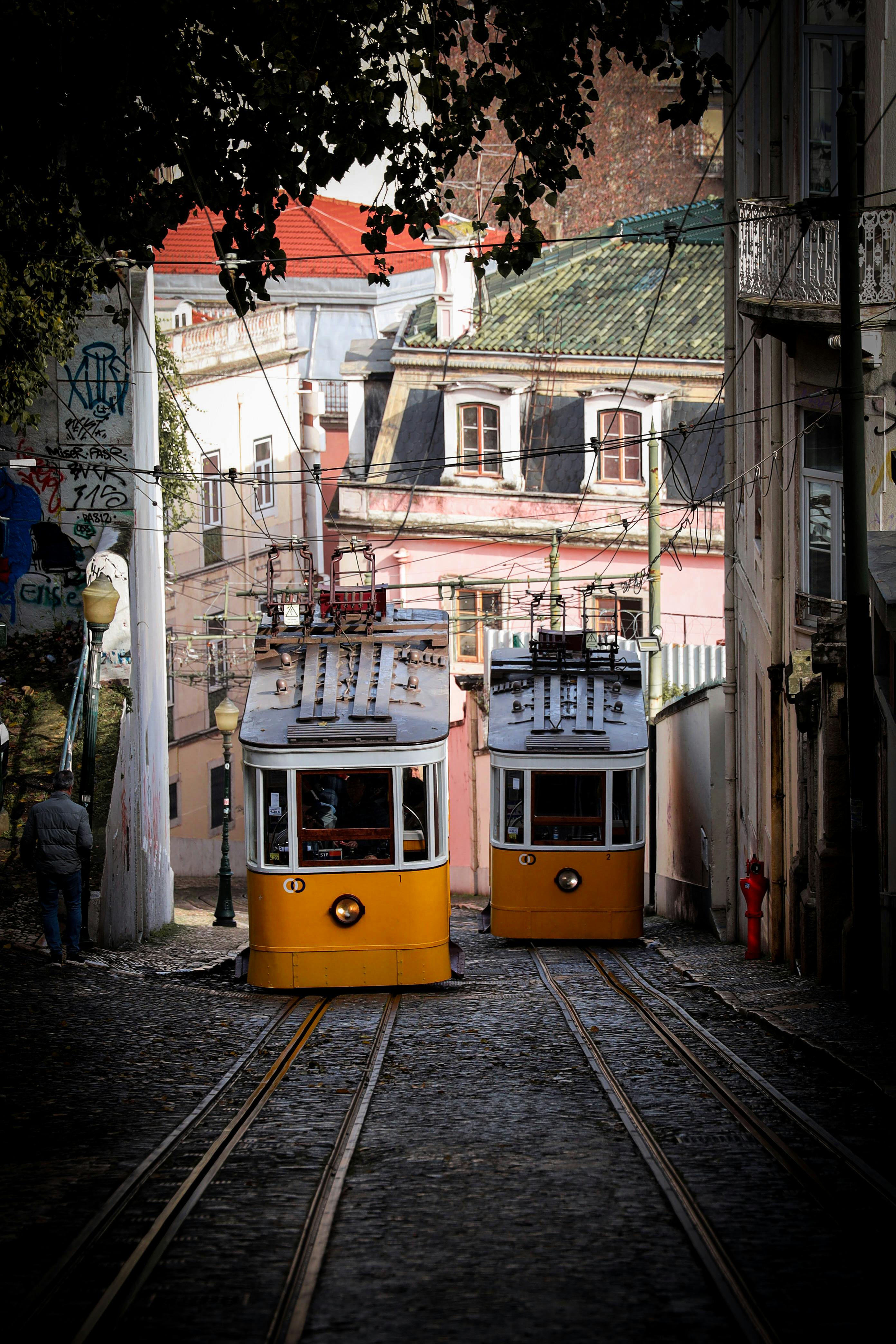 Classic Lisbon Trams on Cobblestone Street · Free Stock Photo