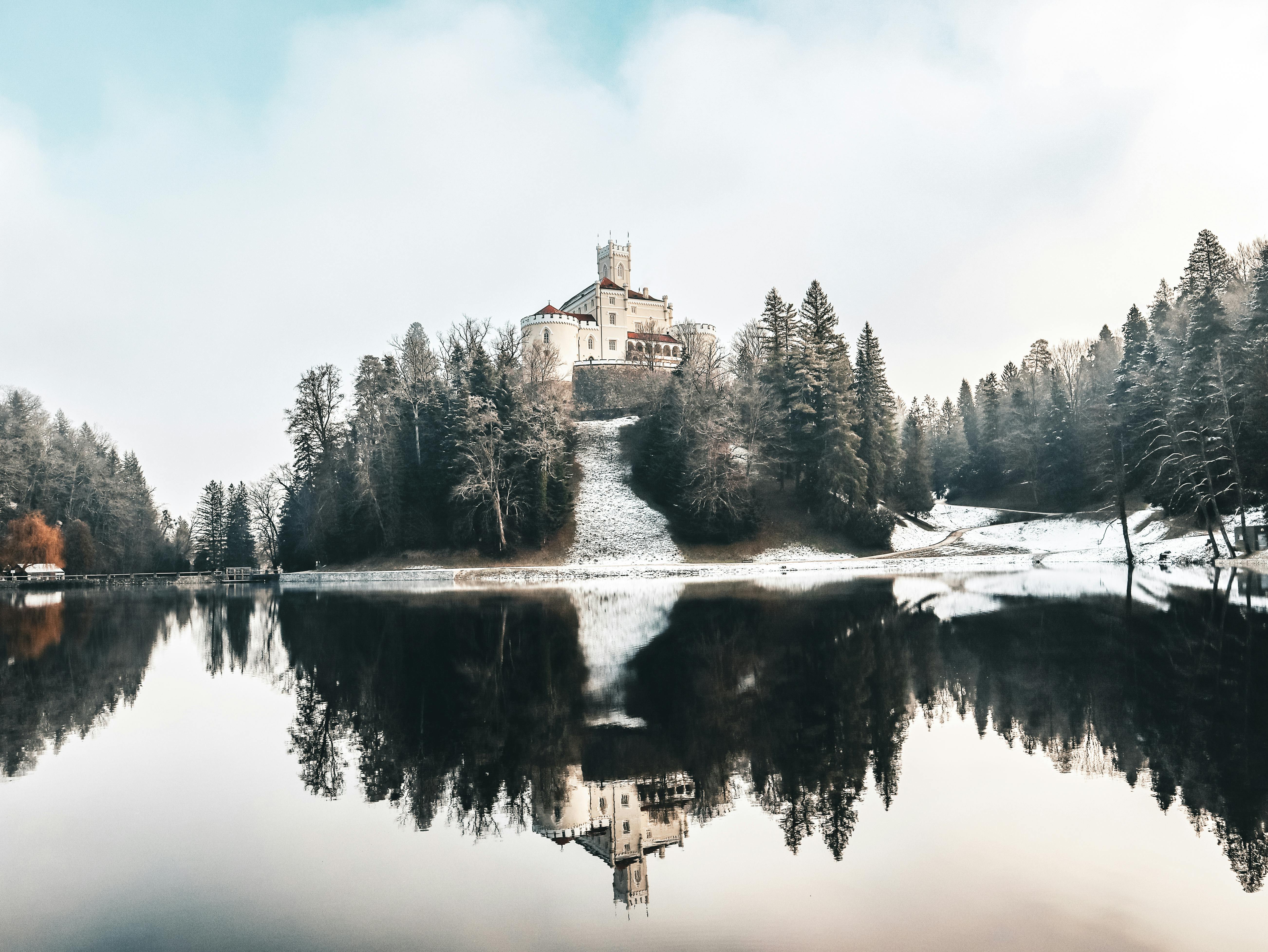 Majestic Winter Castle Reflection in Tranquil Lake · Free Stock Photo