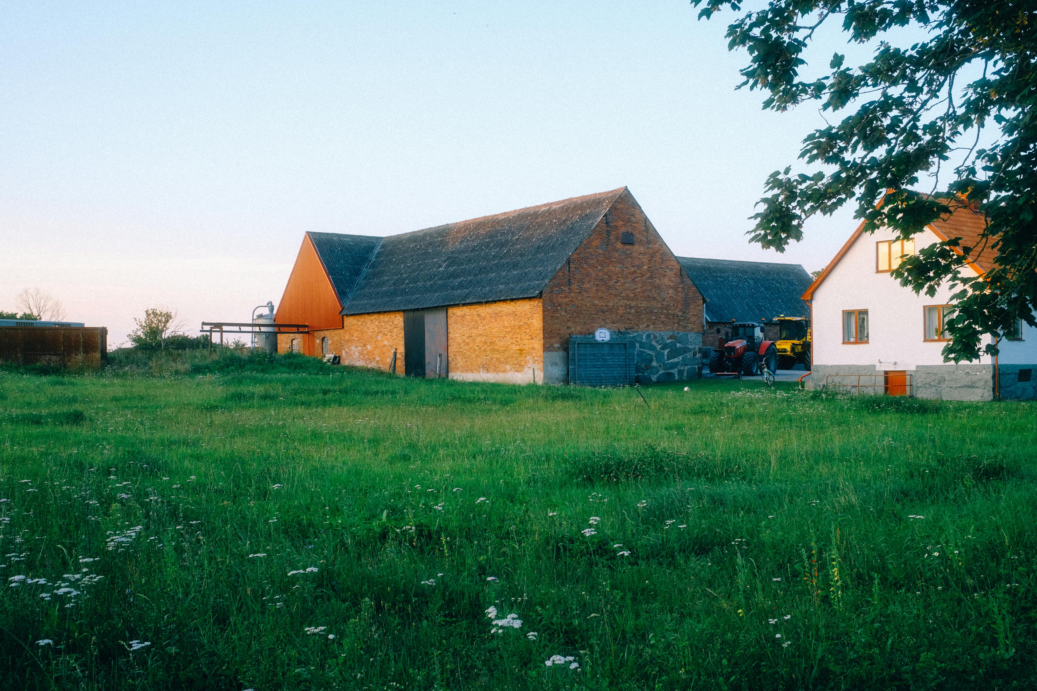 Scenic Farmyard with Traditional Barns at Sunset · Free Stock Photo