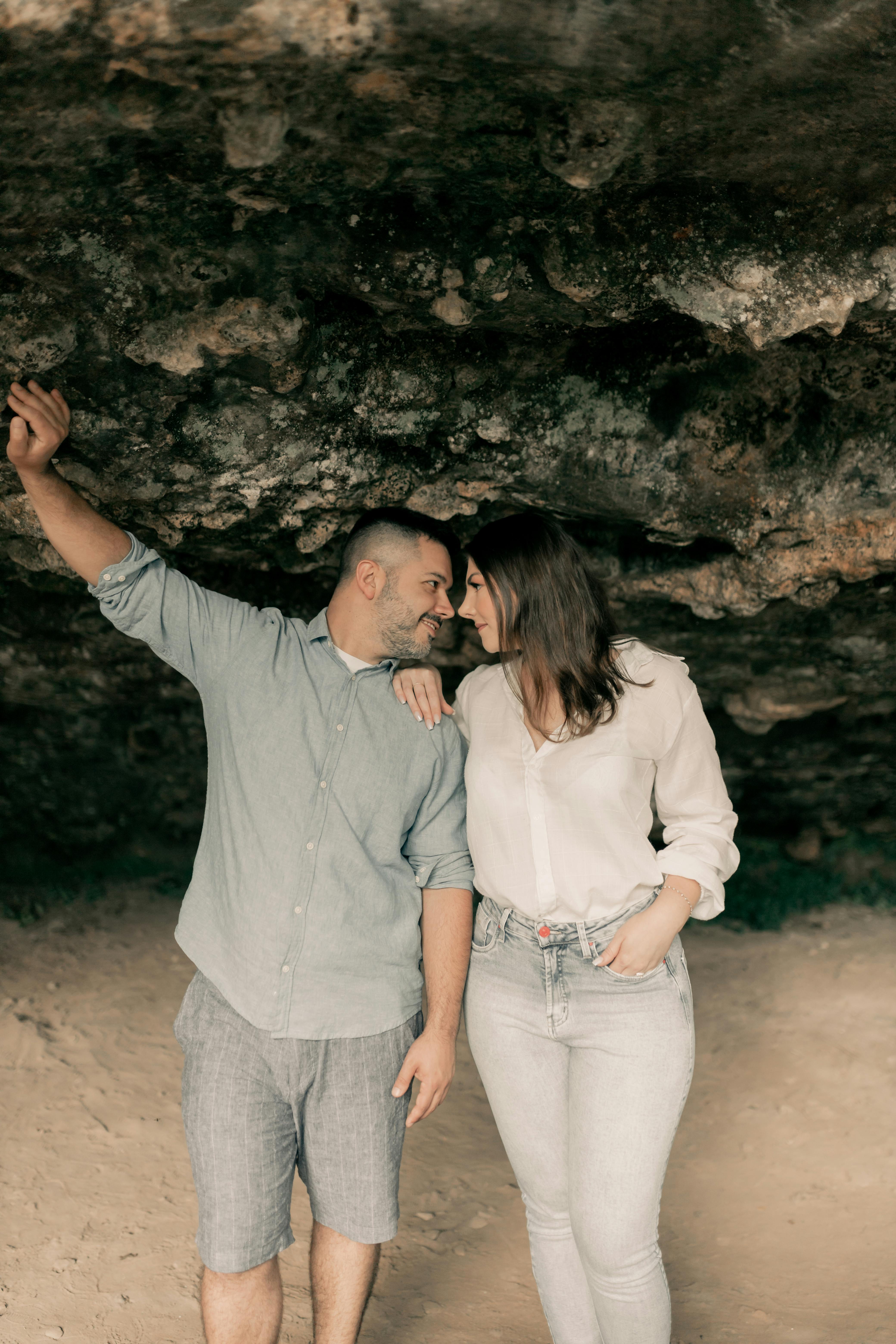 Romantic Couple Explore a Cozy Cave Setting · Free Stock Photo
