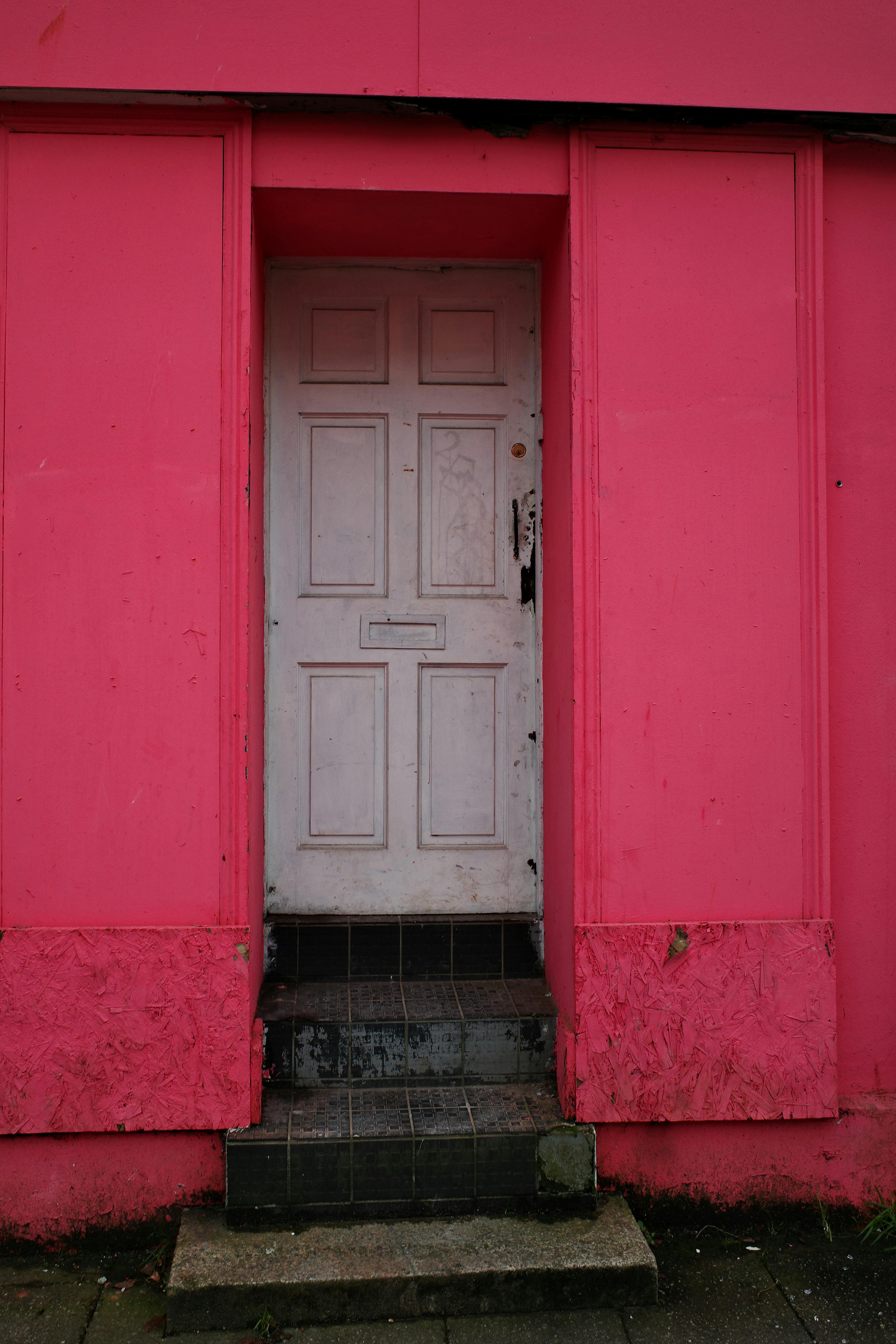 Vibrant Pink Building Facade with White Door · Free Stock Photo