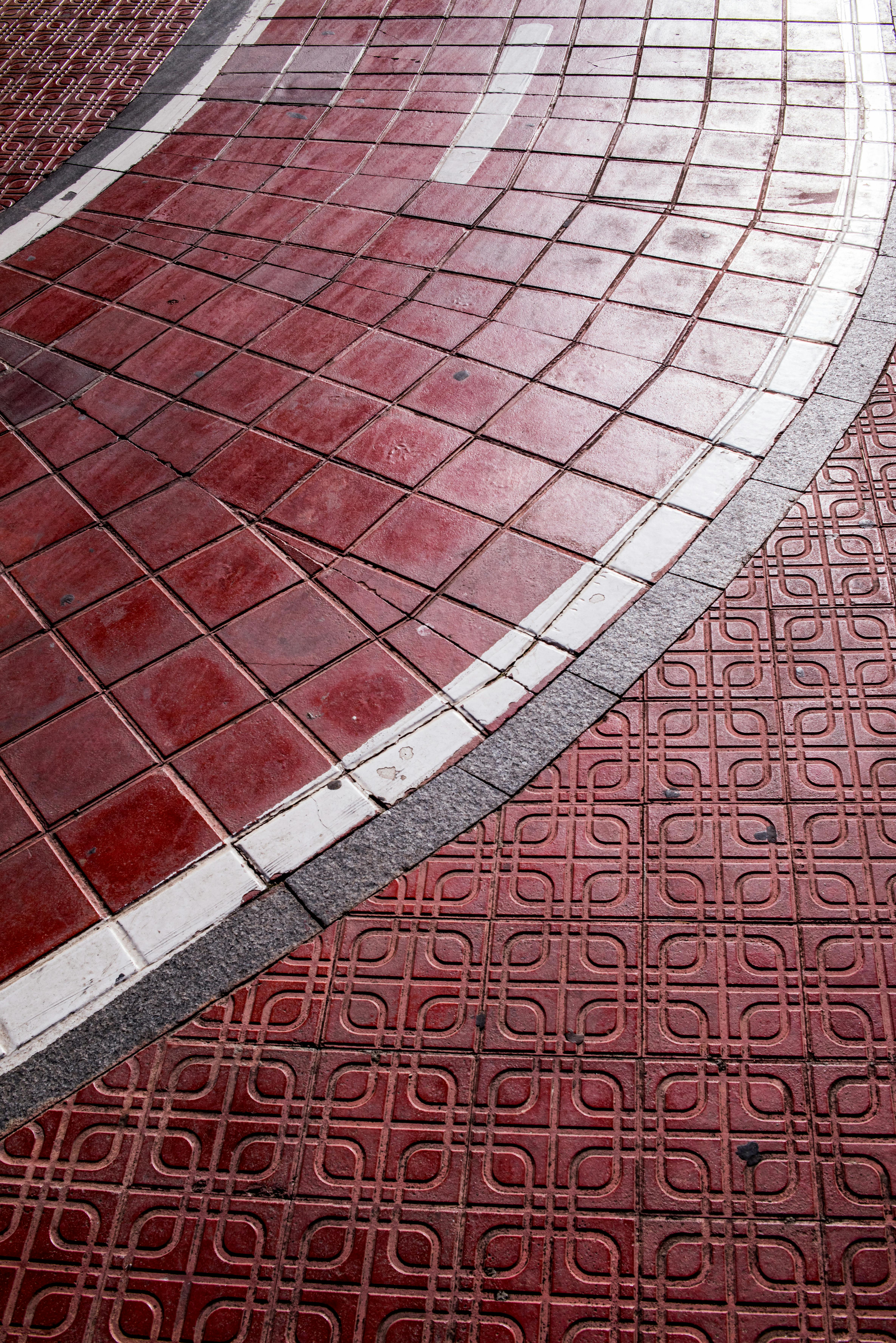 Curved Red Tiled Sidewalk with Geometric Patterns · Free Stock Photo