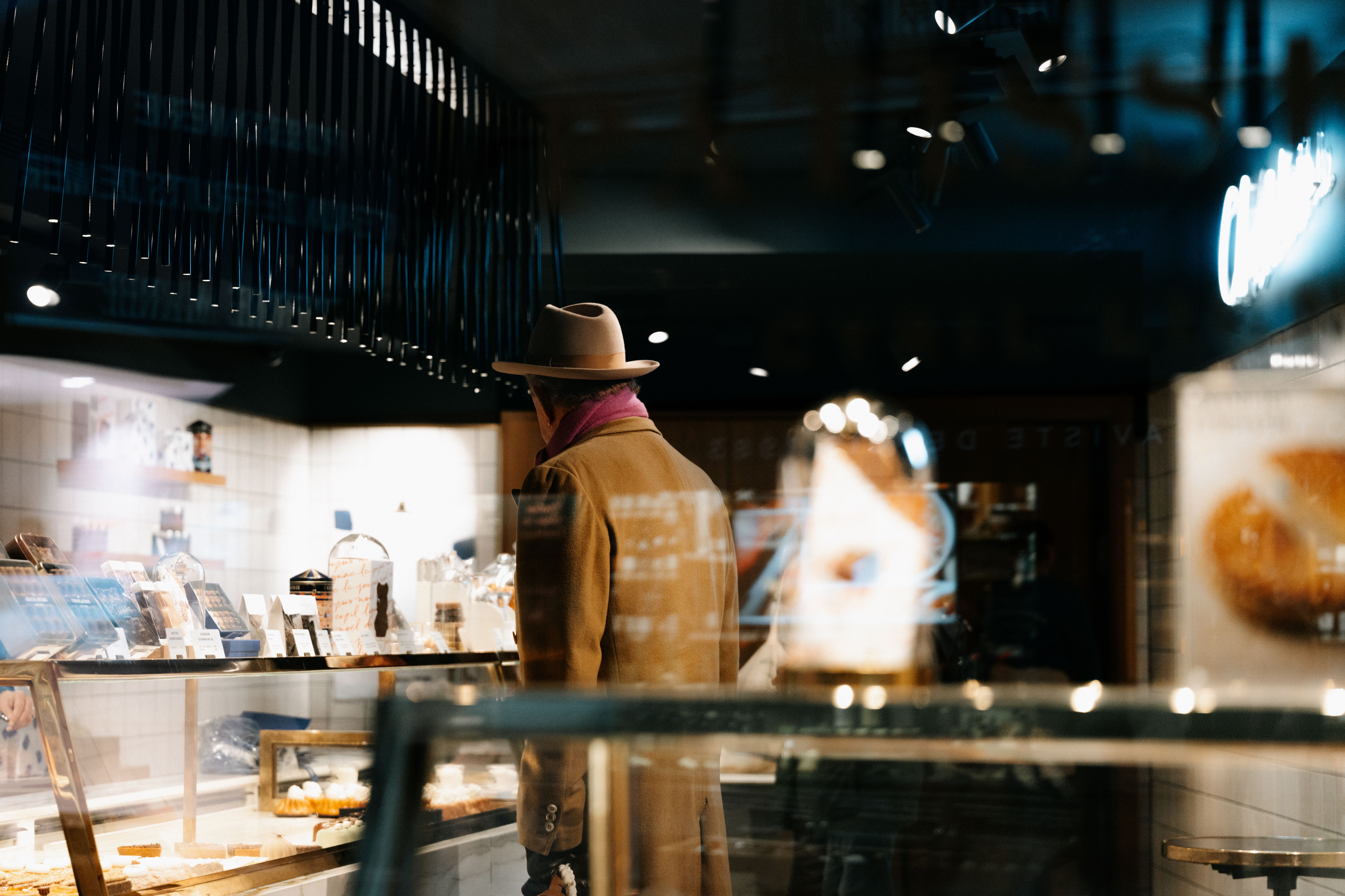 Elegant Man in Parisian Bakery Captured at Night · Free Stock Photo