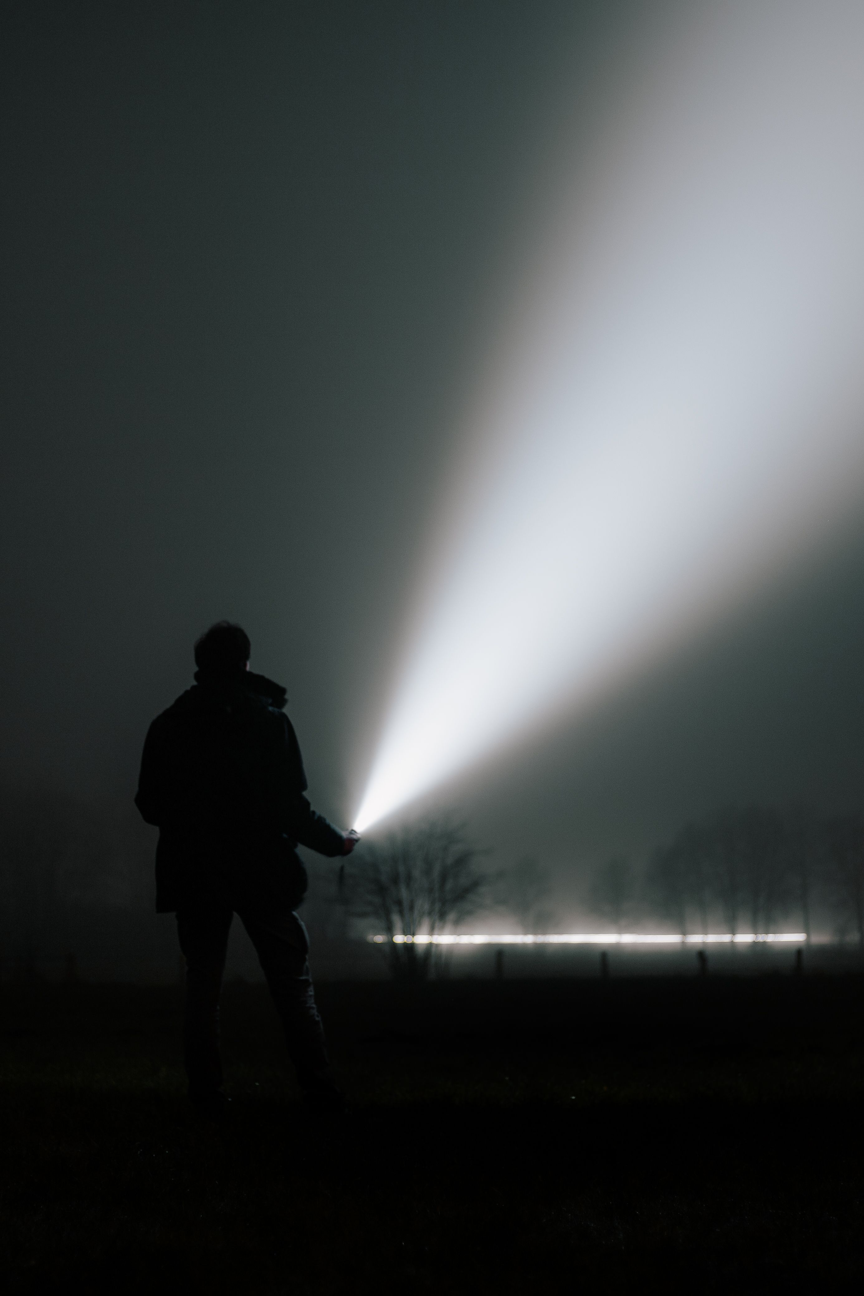 Silhouette of Person with Flashlight in Foggy Night · Free Stock Photo