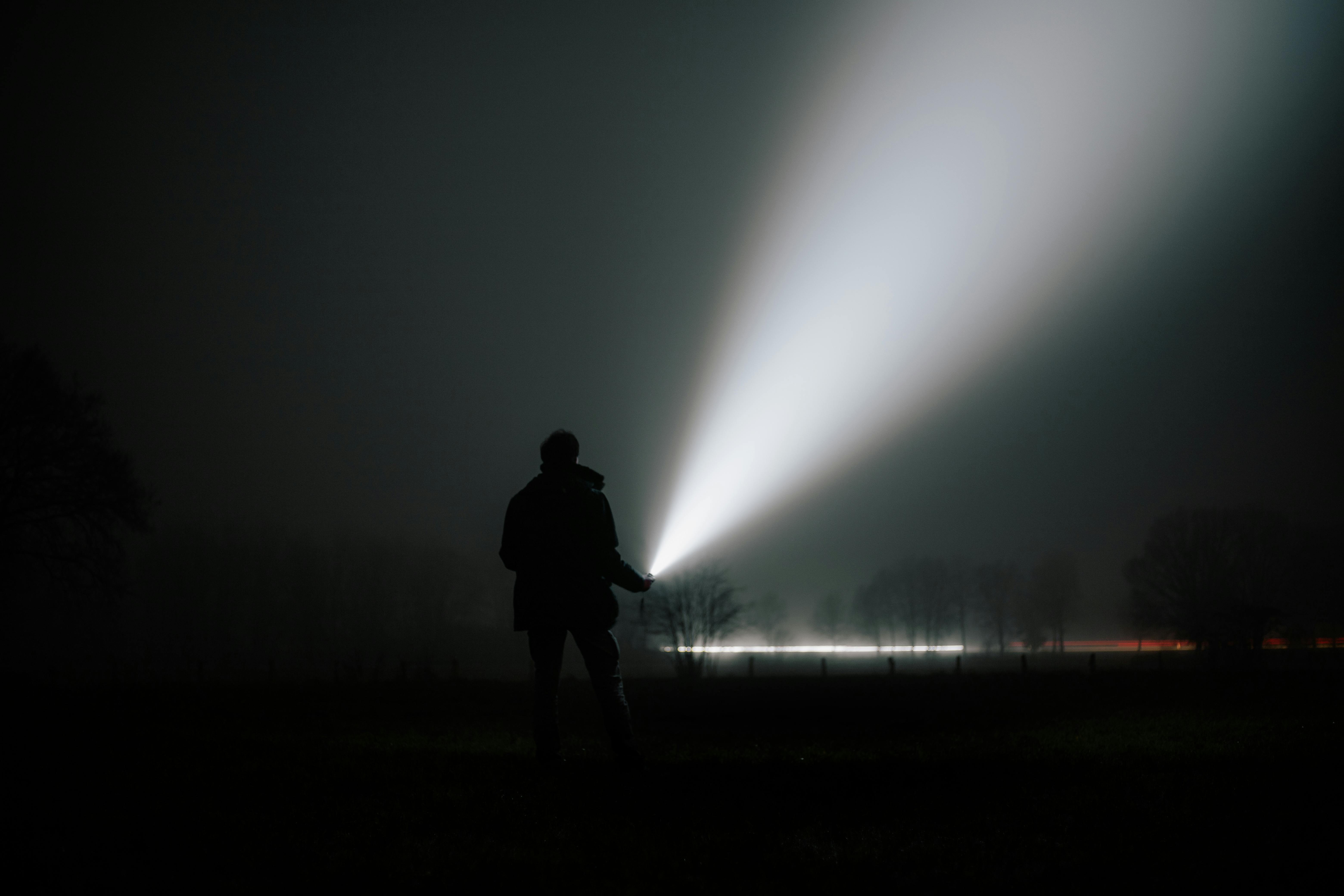 Silhouette with Flashlight in Foggy Night Scene · Free Stock Photo