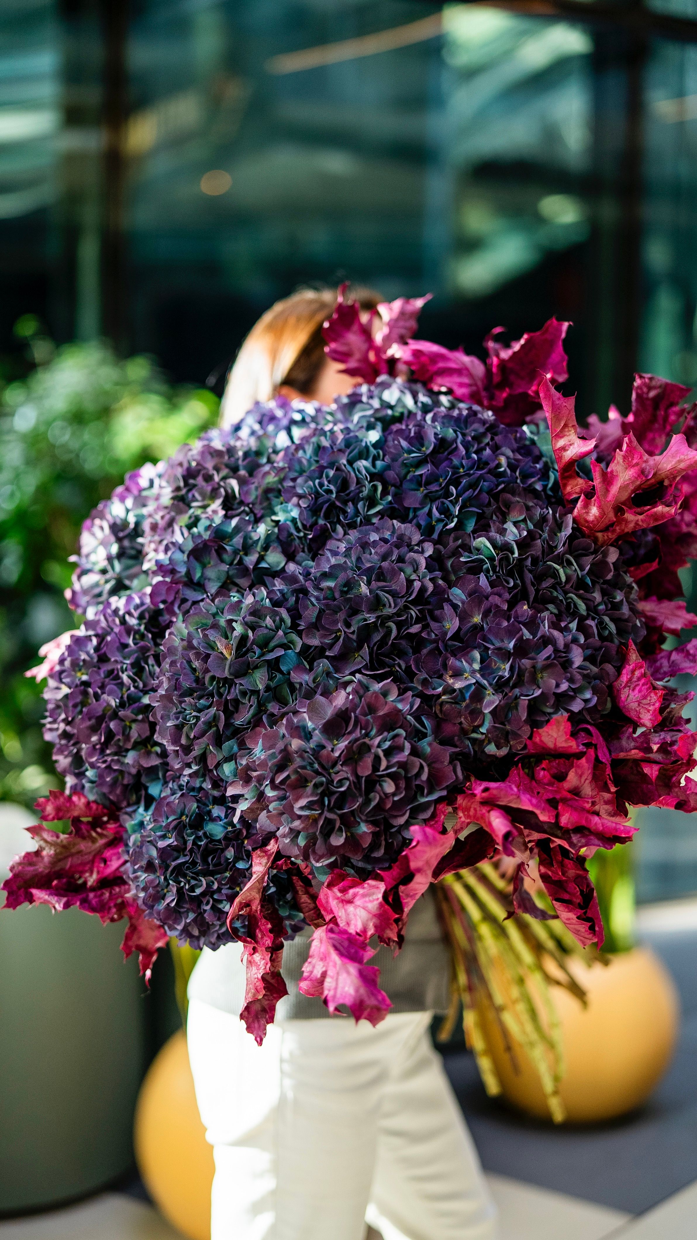 Woman Carrying Large Bouquet of Vibrant Flowers · Free Stock Photo