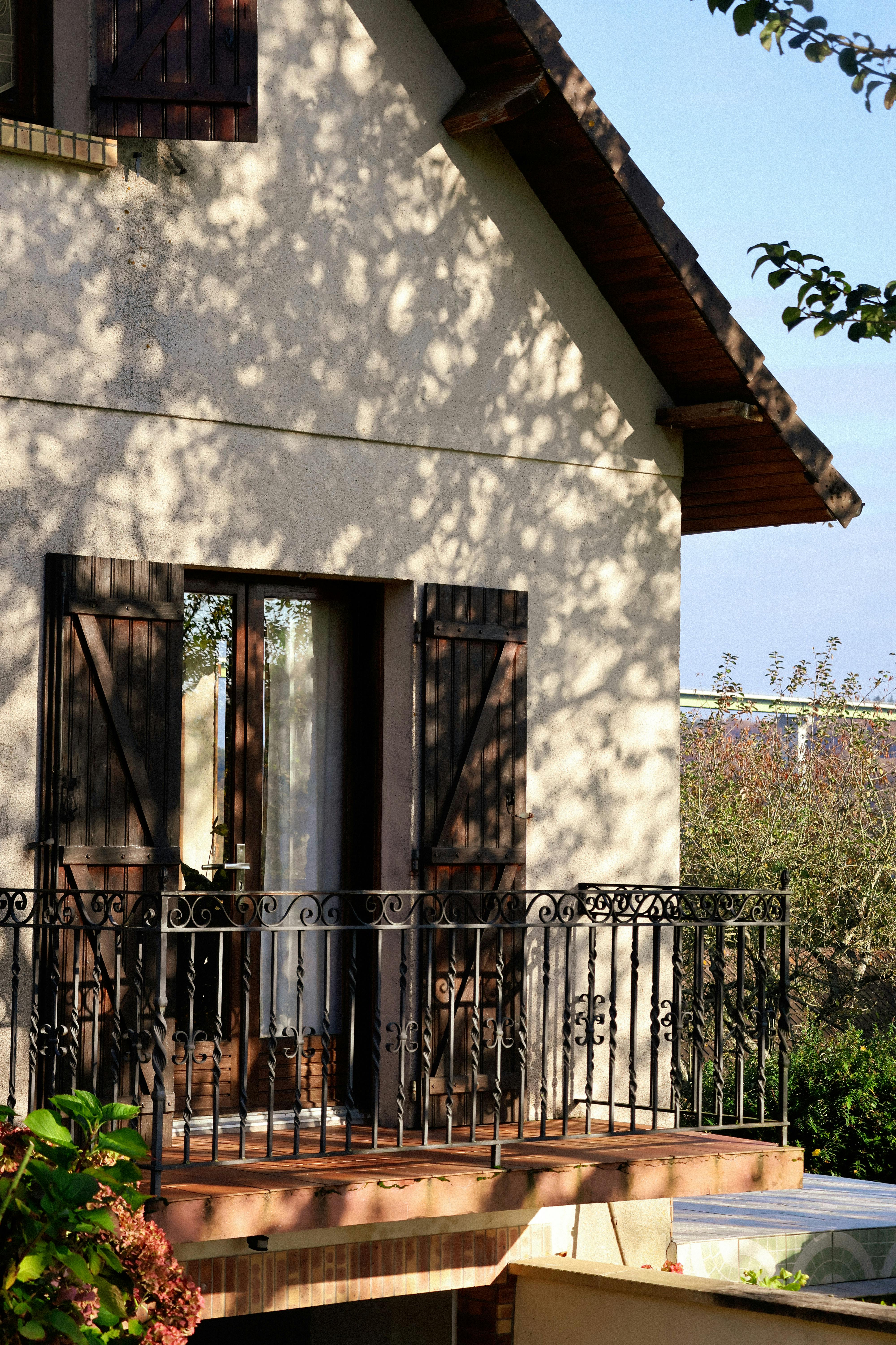 Charming Sunlit House with Rustic Balcony · Free Stock Photo