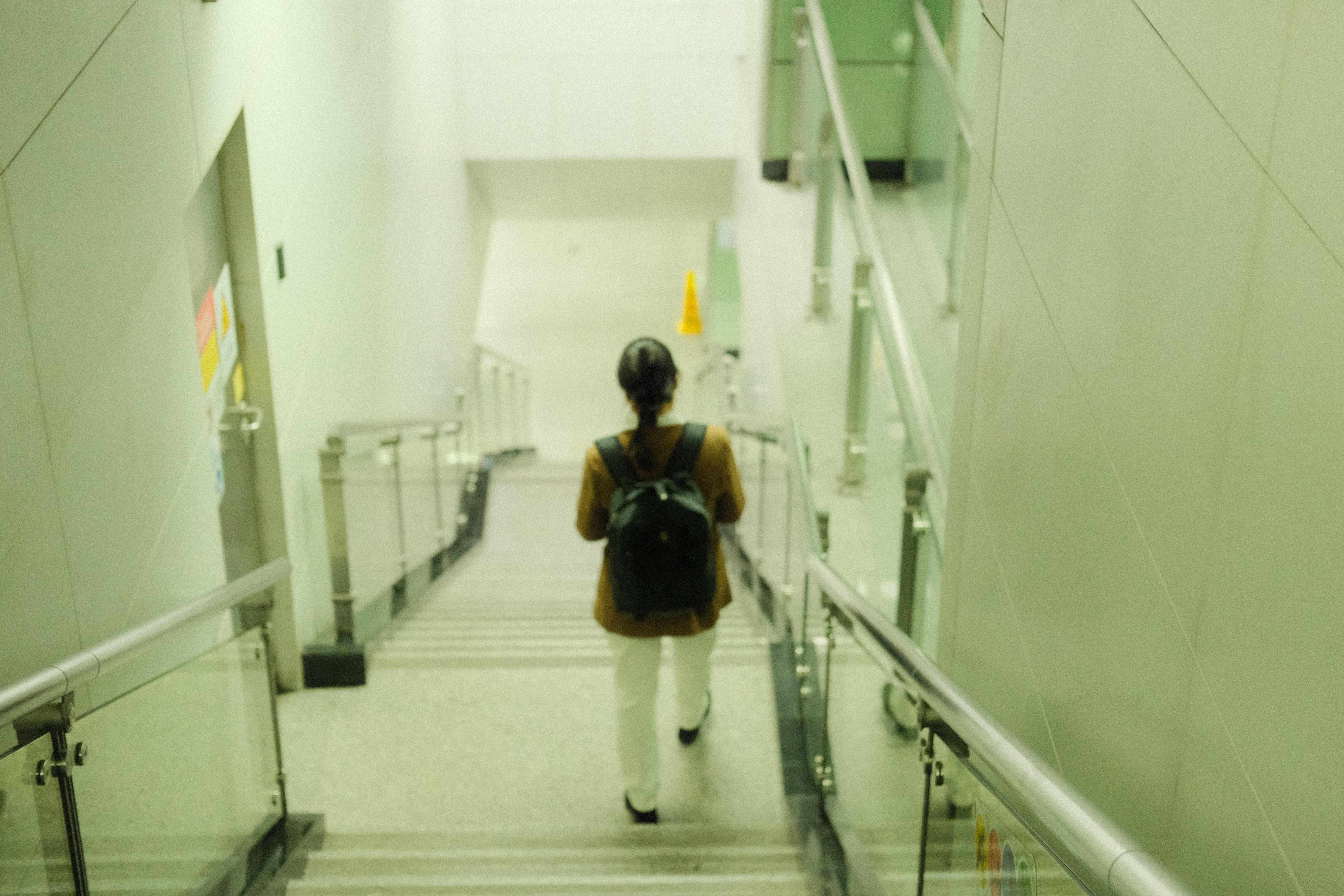 Person Descending Indoor Staircase with Backpack · Free Stock Photo