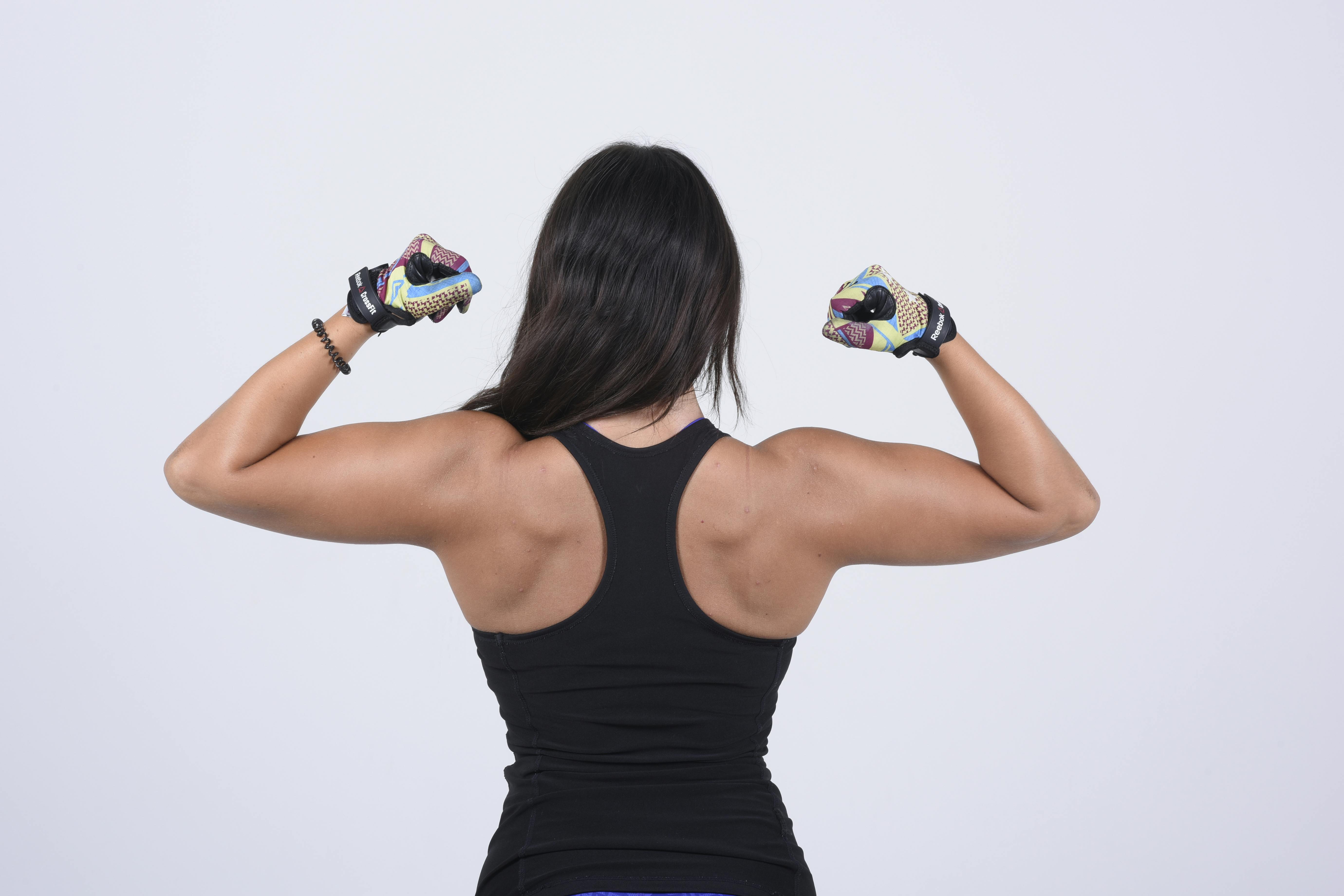 Strong Woman Flexing Muscles in Fitness Attire · Free Stock Photo