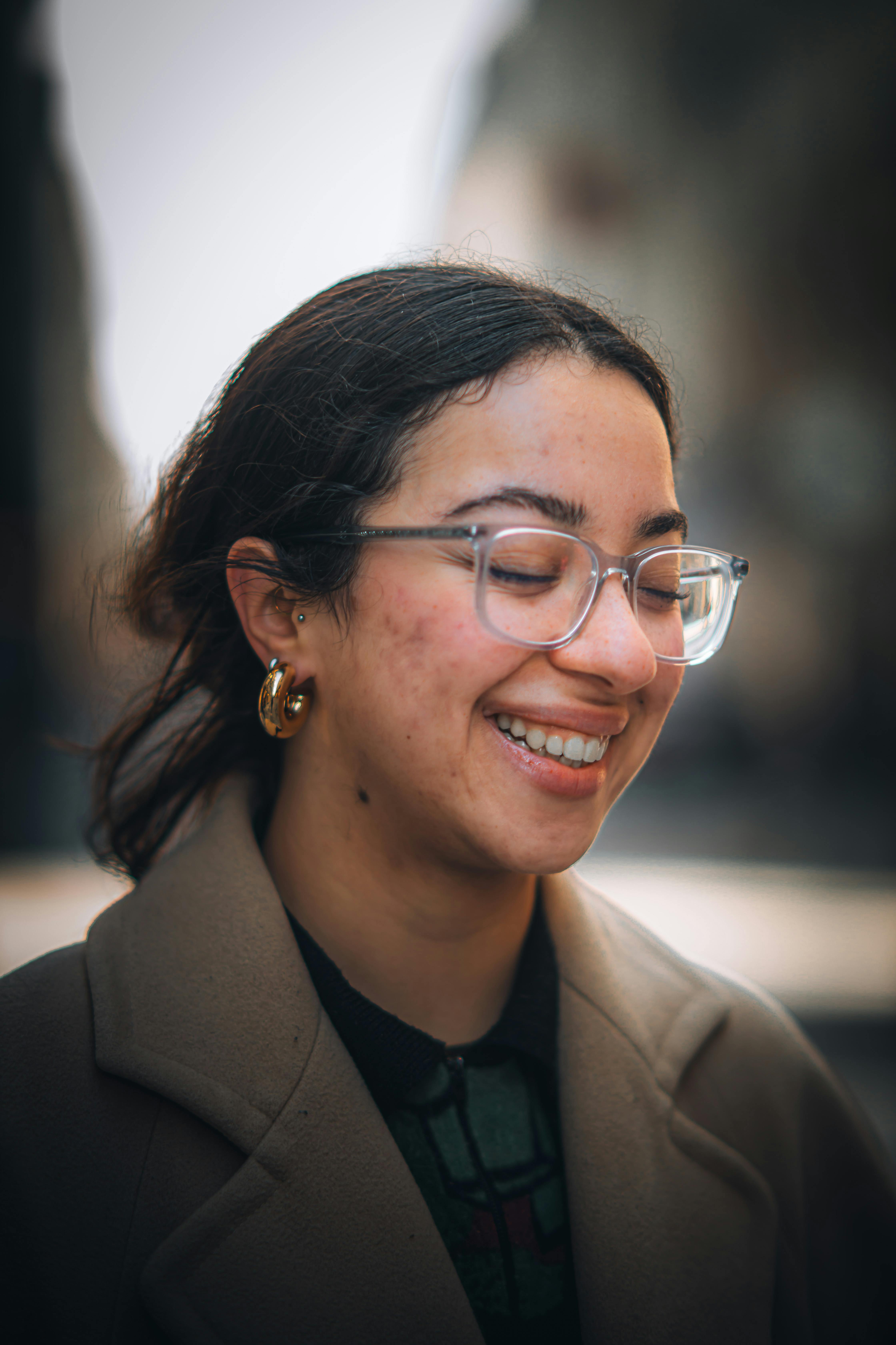 Smiling Woman with Glasses in Urban Setting · Free Stock Photo